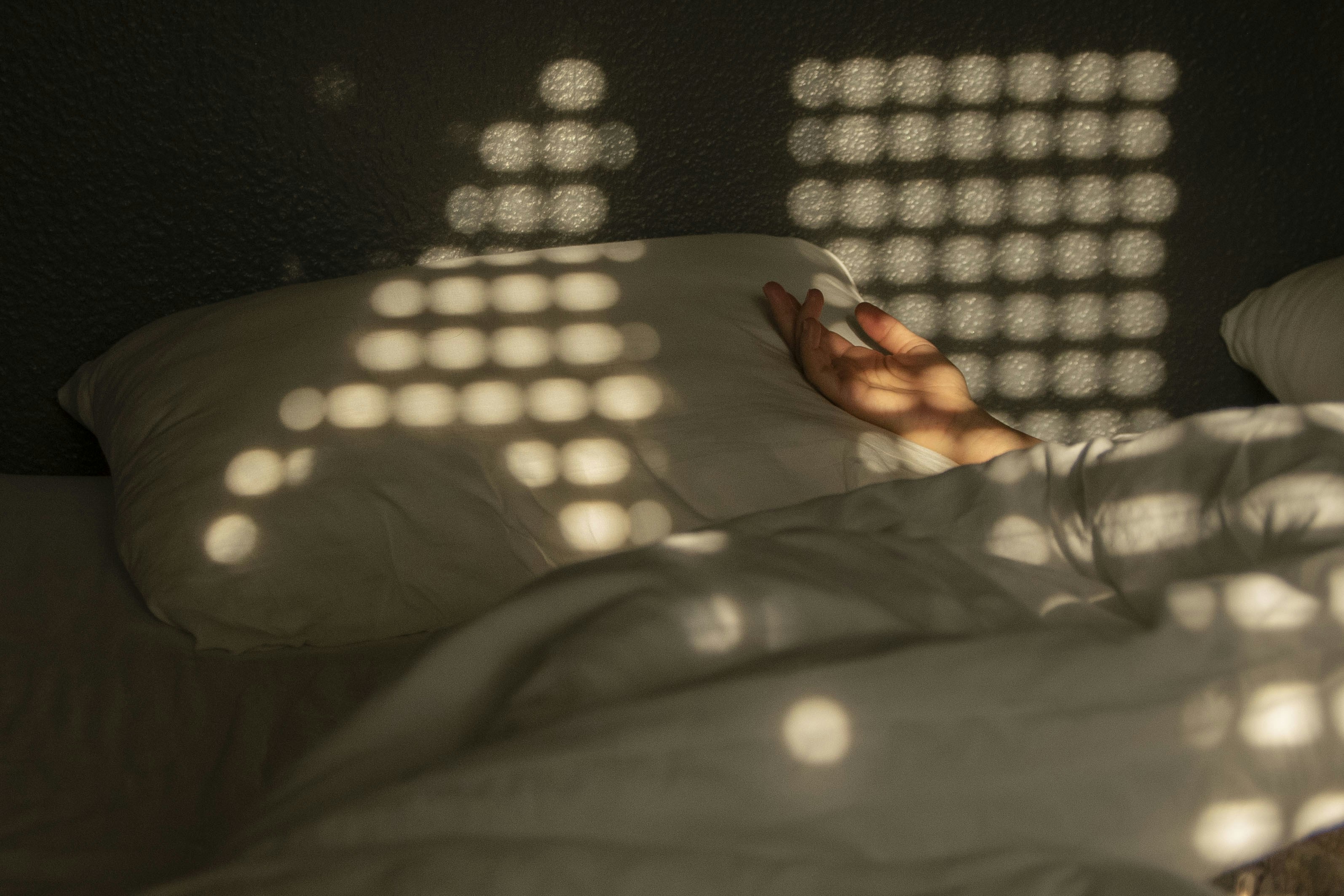A person laying in a bed with a shadow on the wall photo – Free Cádiz ...