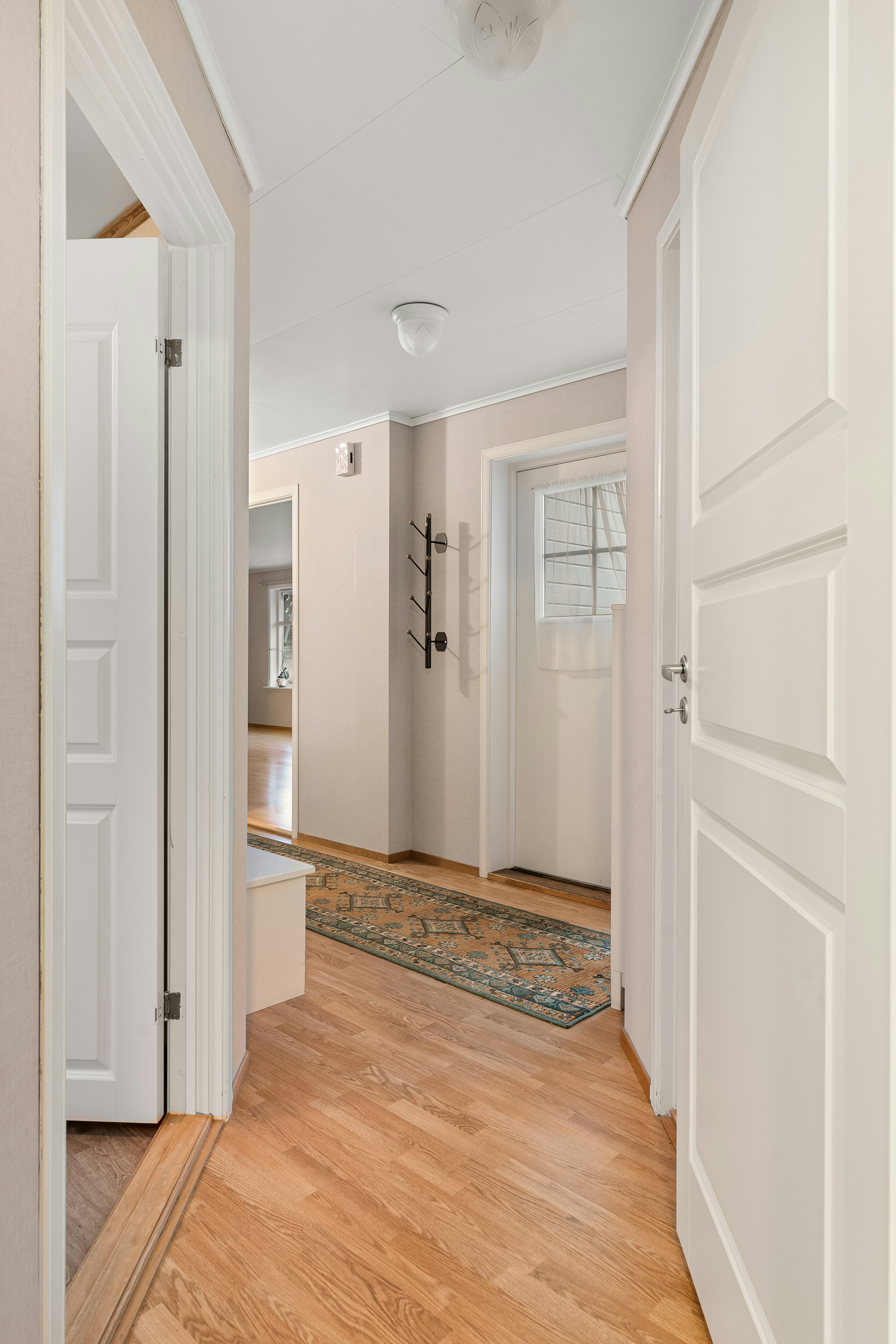A long hallway with a white door and wooden floors photo – Free Indoors ...