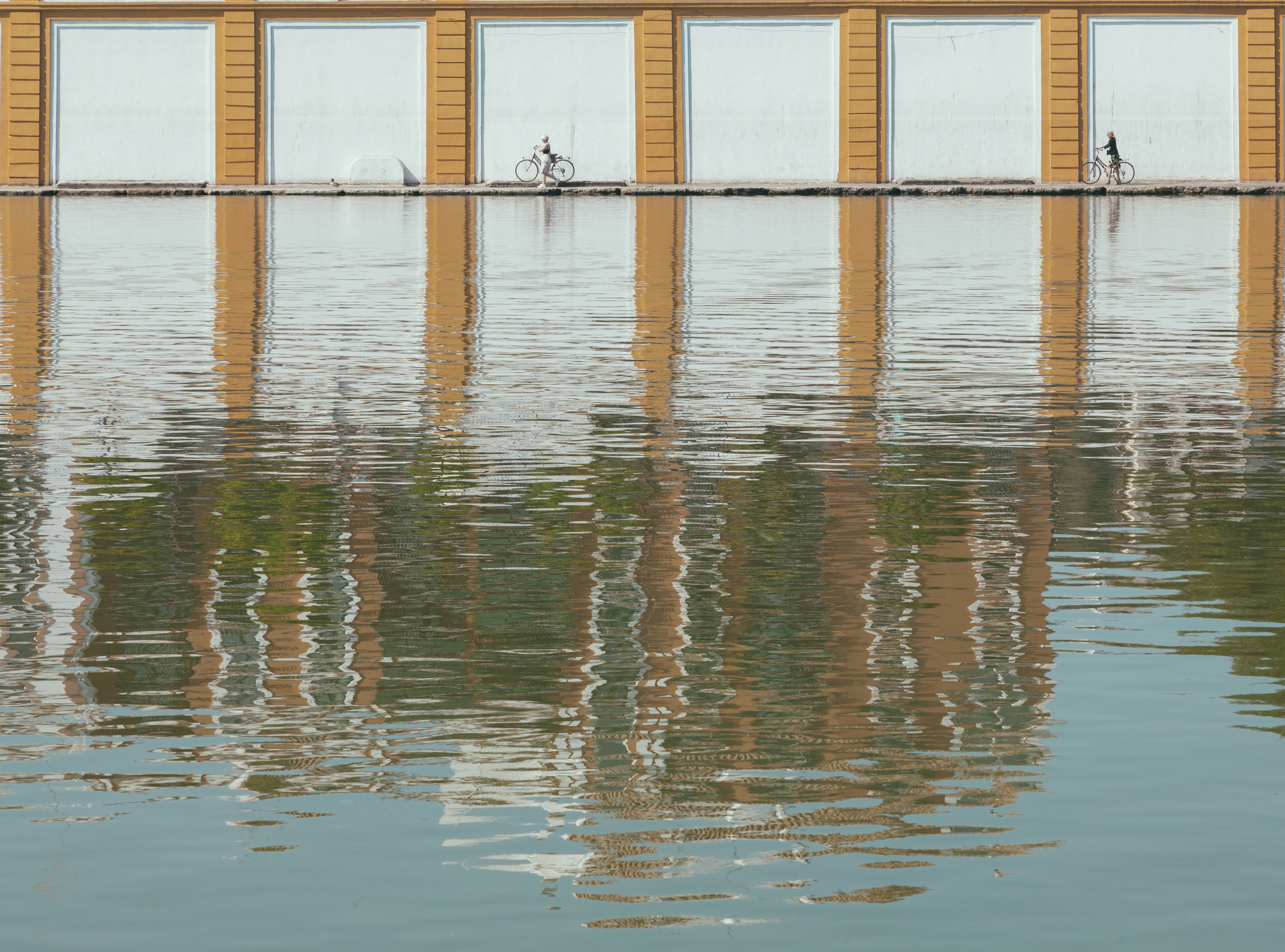 A large body of water with a yellow structure in the middle of it photo ...