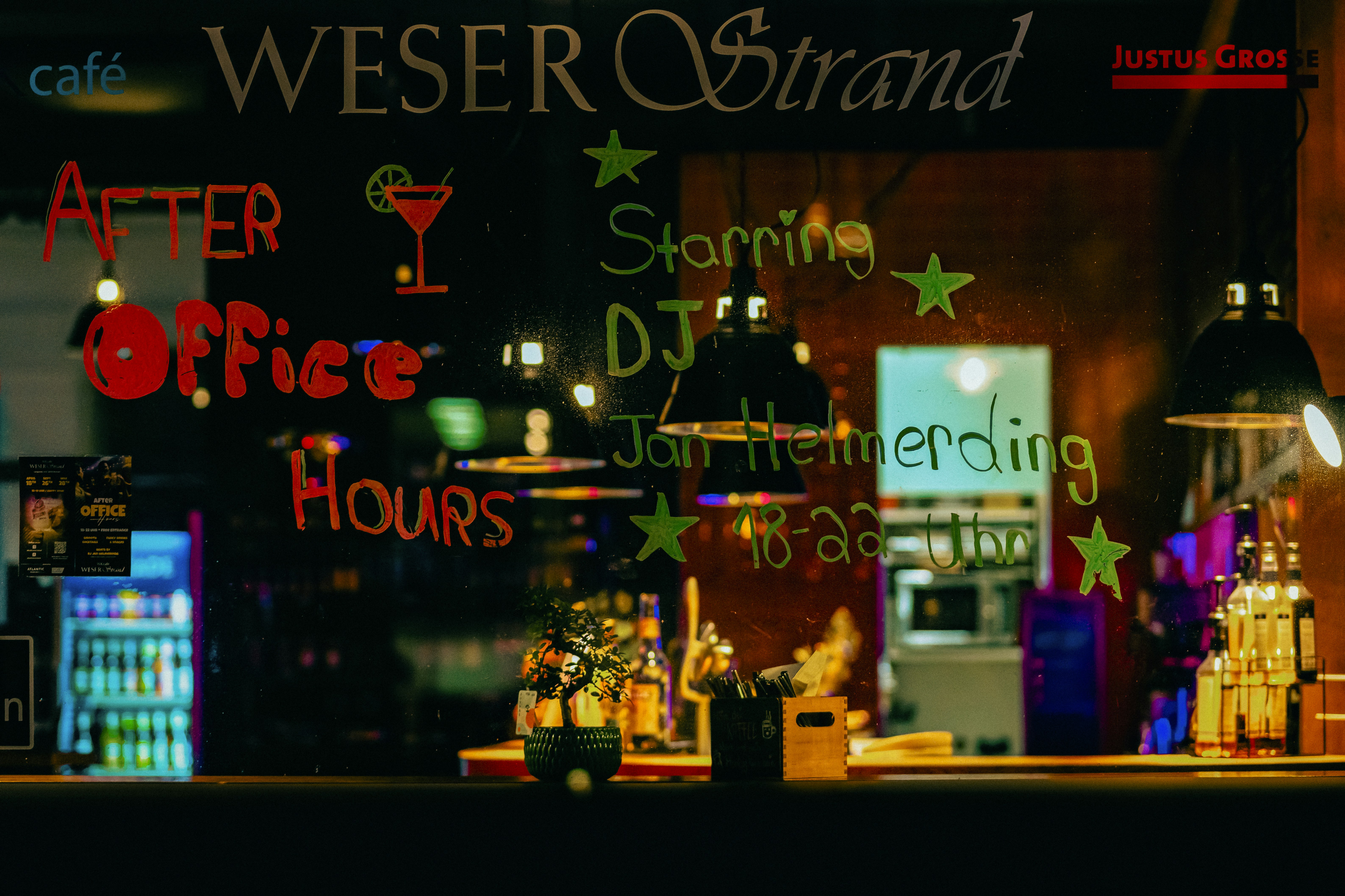 Neon Scribbles Over Warm Glass: Night at Weser Strand Café