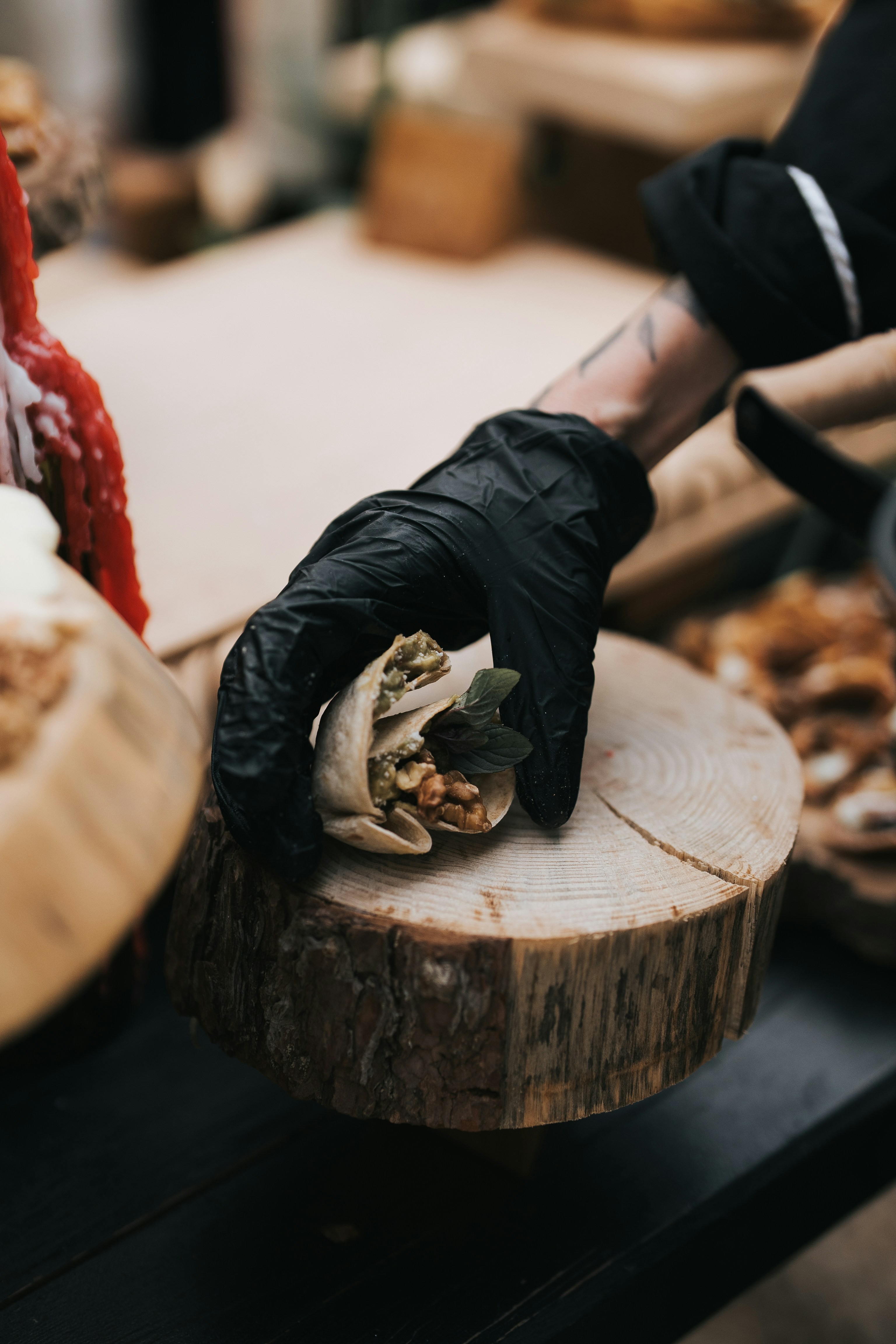 A person wearing black gloves is preparing food