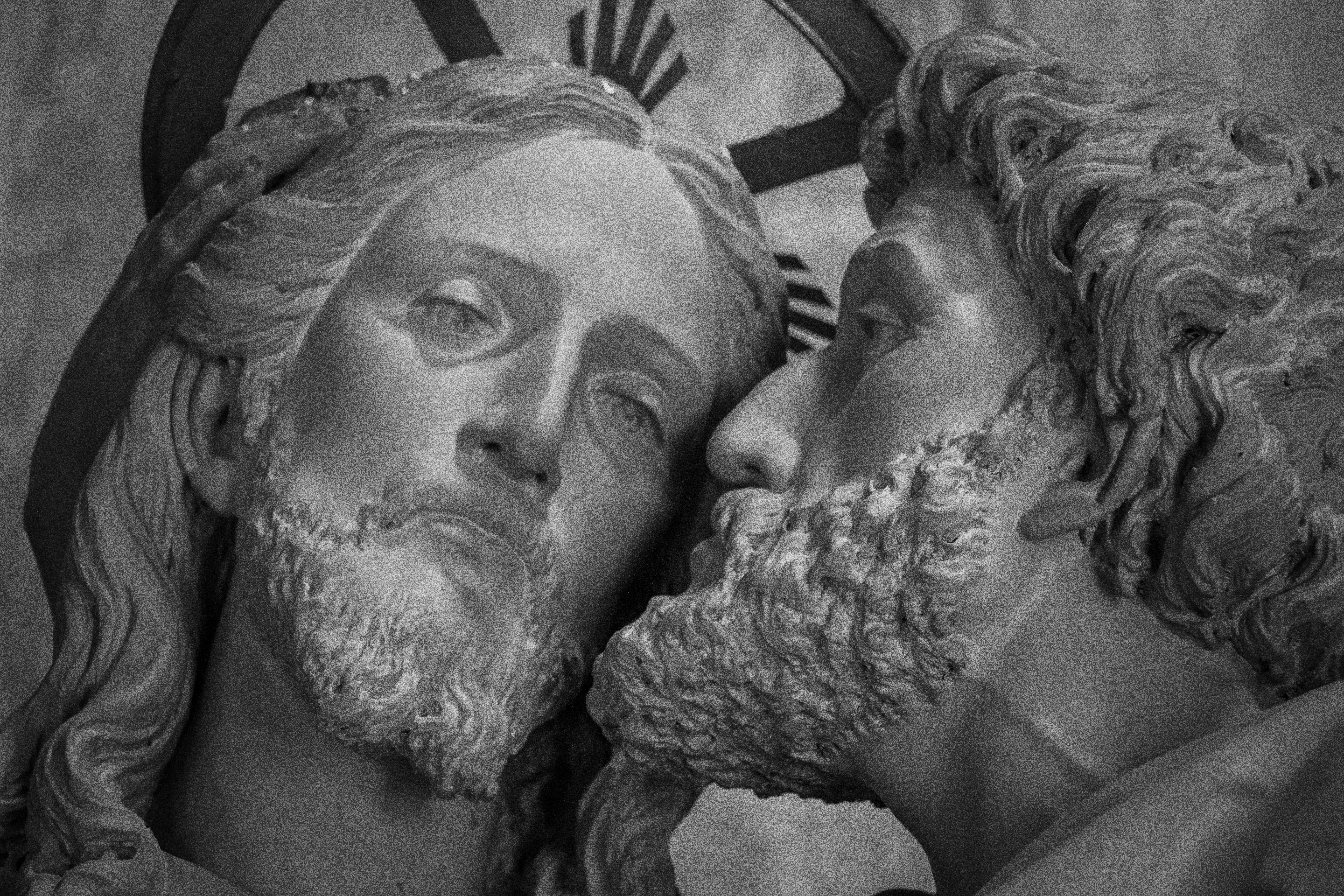 A black and white photo of two statues of jesus