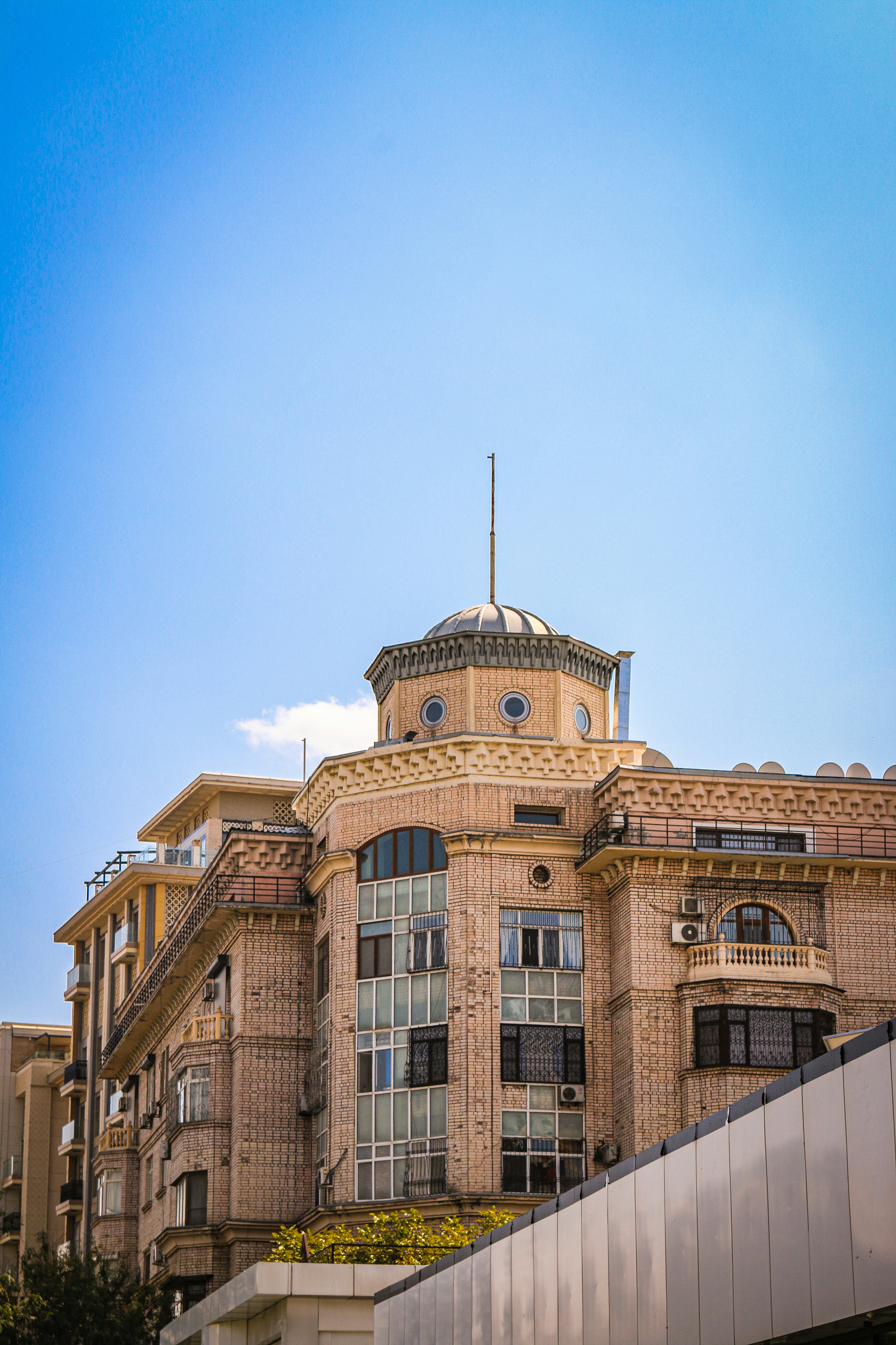Historic building with a clock tower and intricate masonry against a clear blue sky.