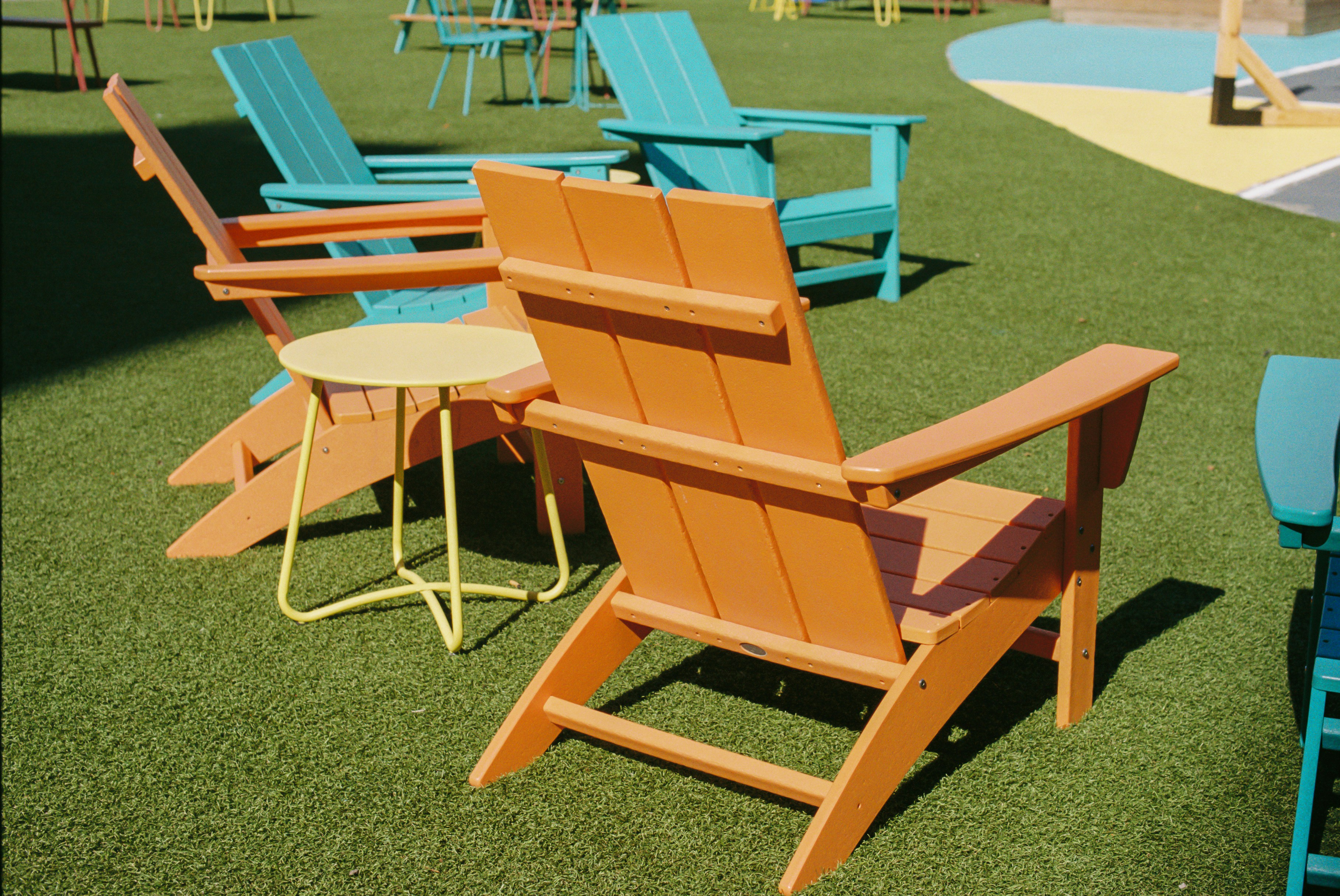 A row of lawn chairs sitting on top of a lush green field photo – Free ...