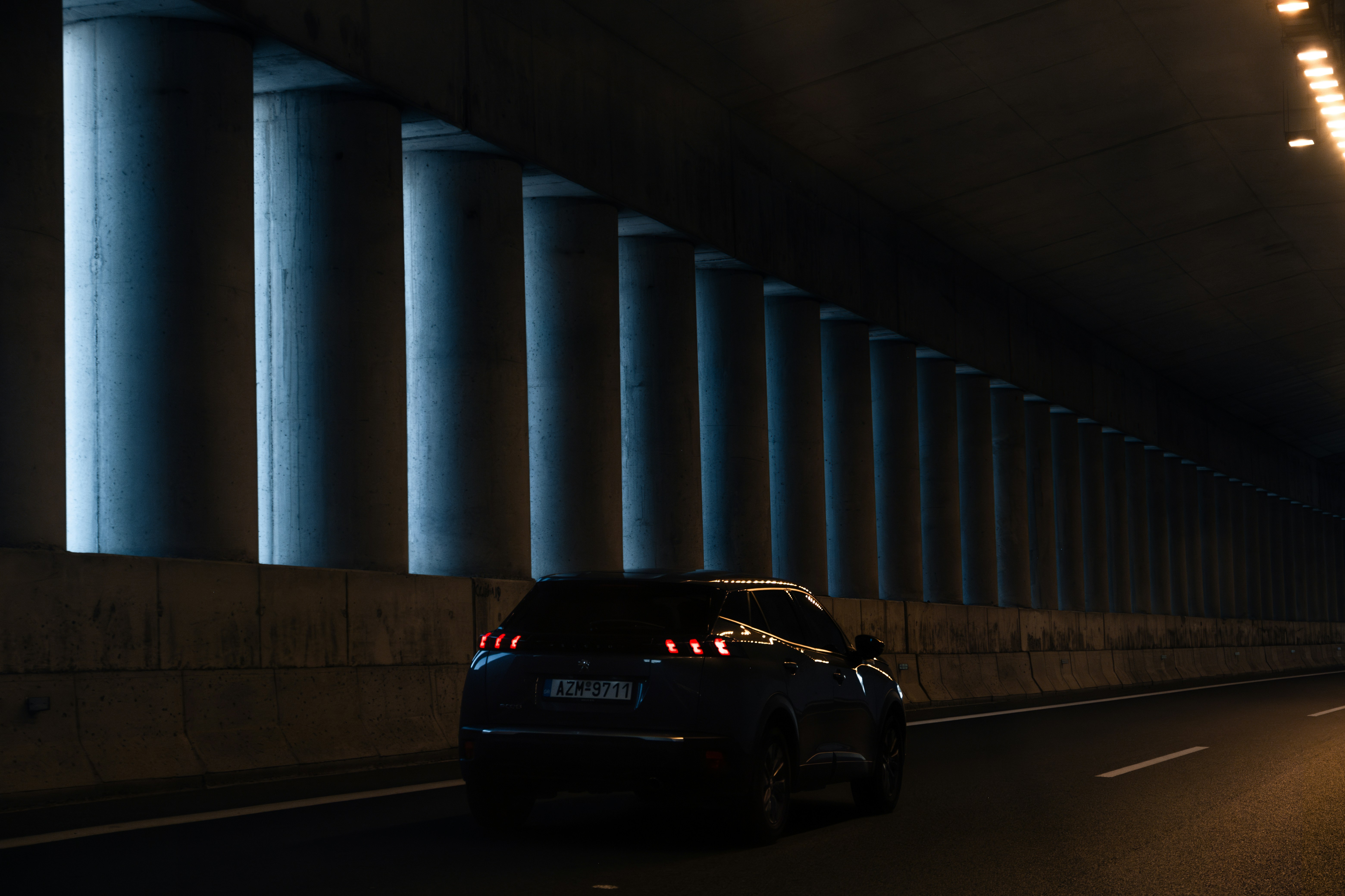 Blue-Cascade Tunnel Drive: A Black SUV in the Night