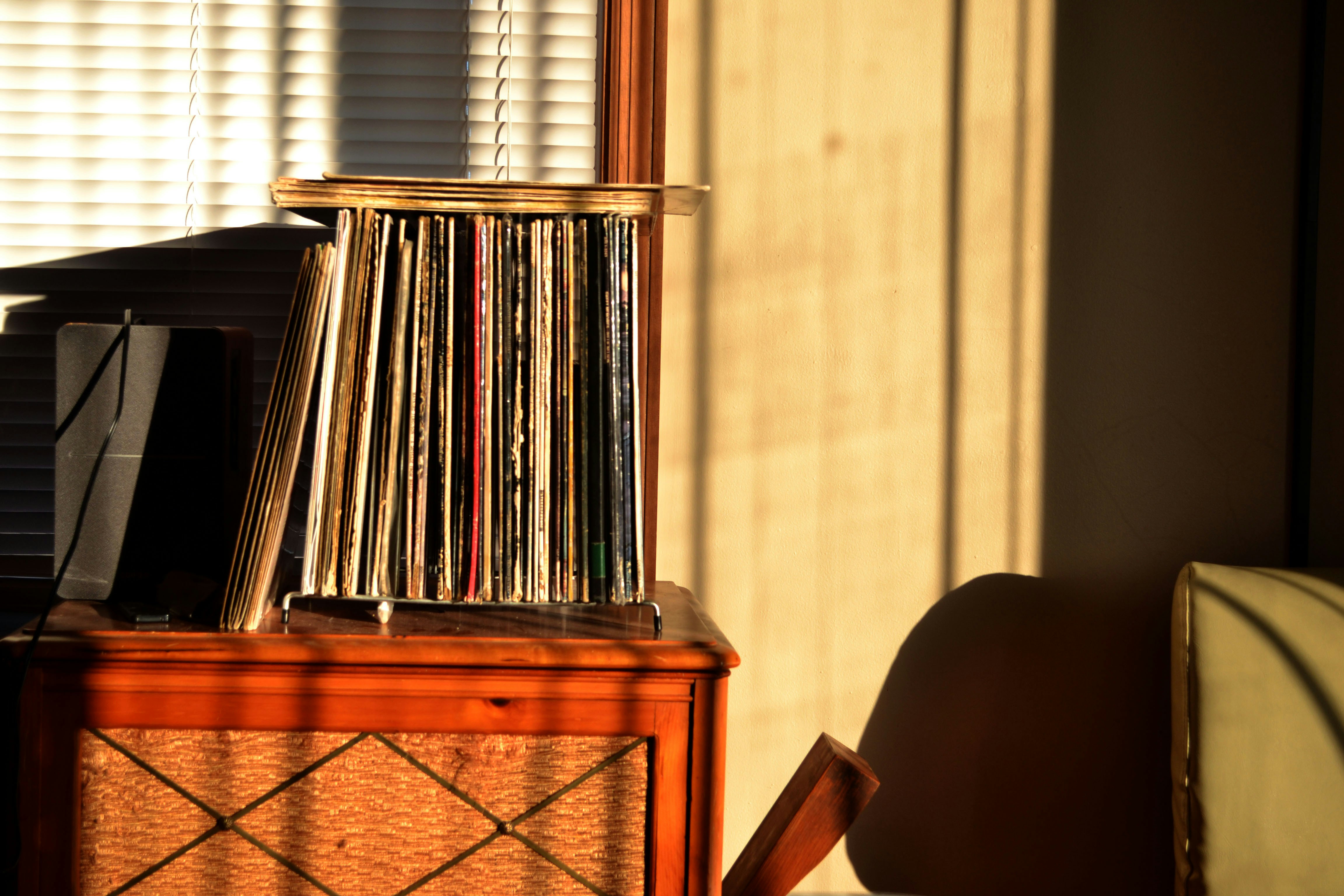Sunlit Vinyl Stack by a Vintage Cabinet in a Quiet Corner