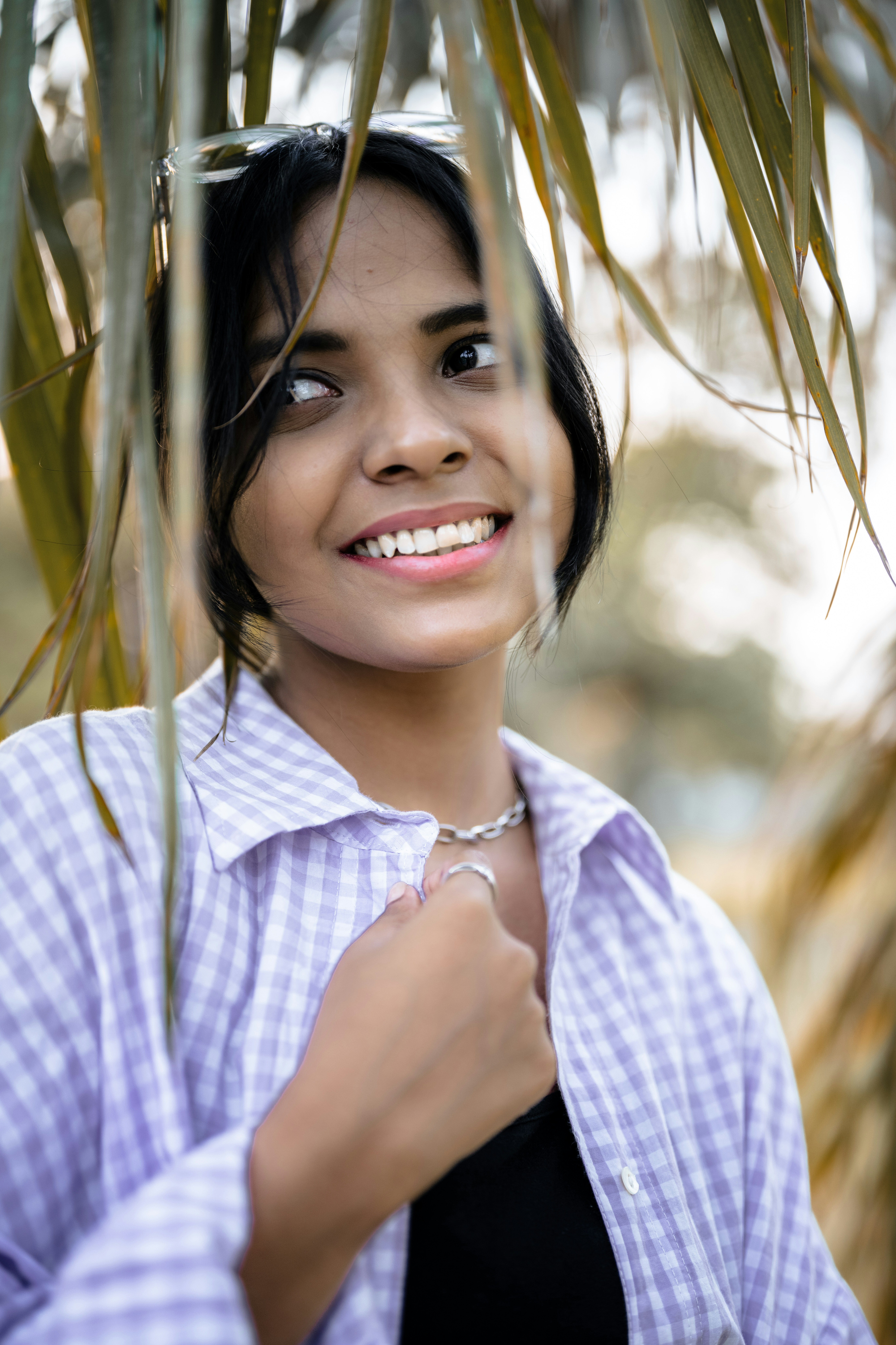 A woman standing under a palm tree with a smile on her face photo ...