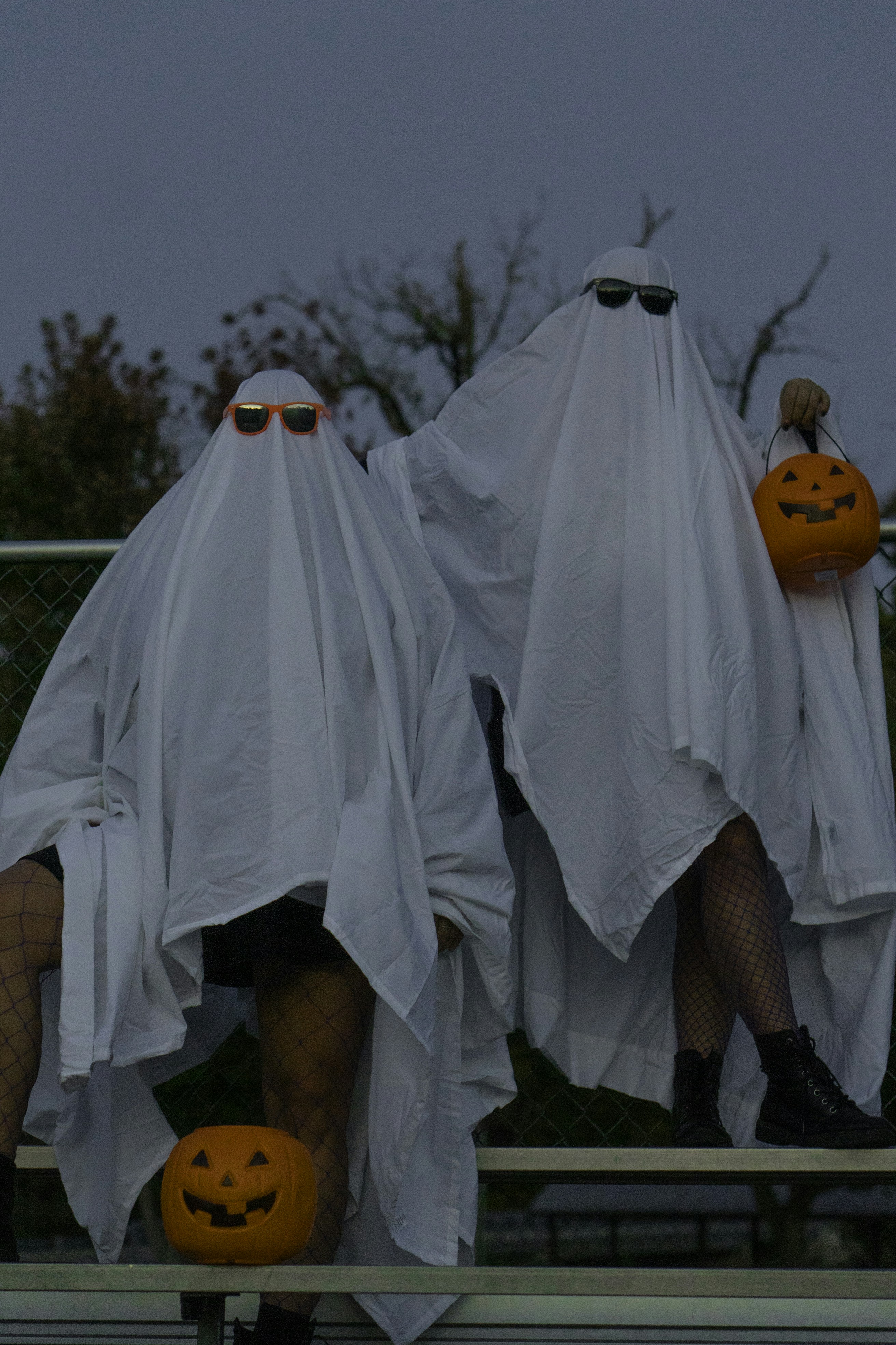 Ghostly Trio on the Bleachers with Jack-o'-Lanterns