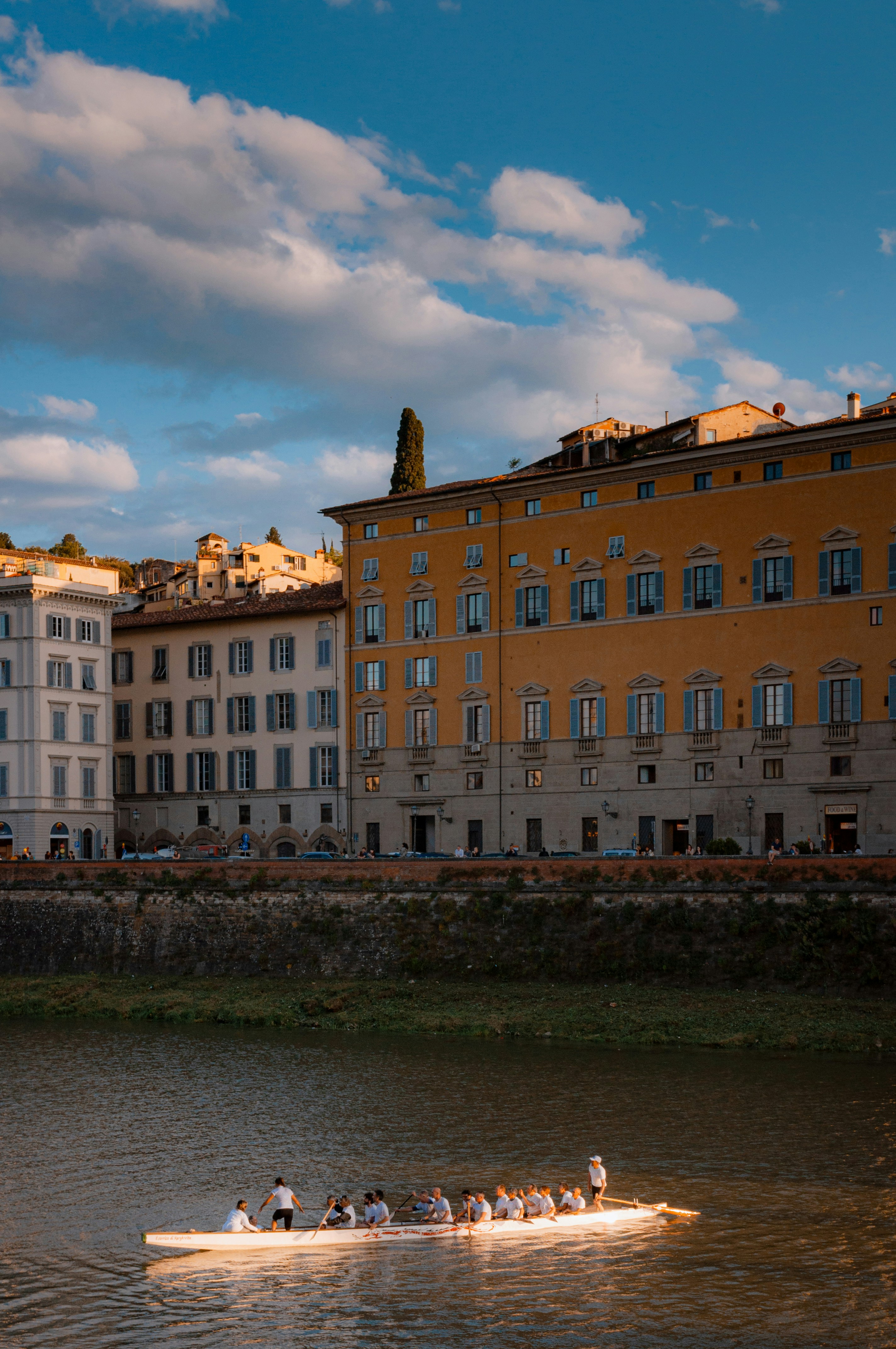 Rowers Glide by Golden Facades on the Arno
