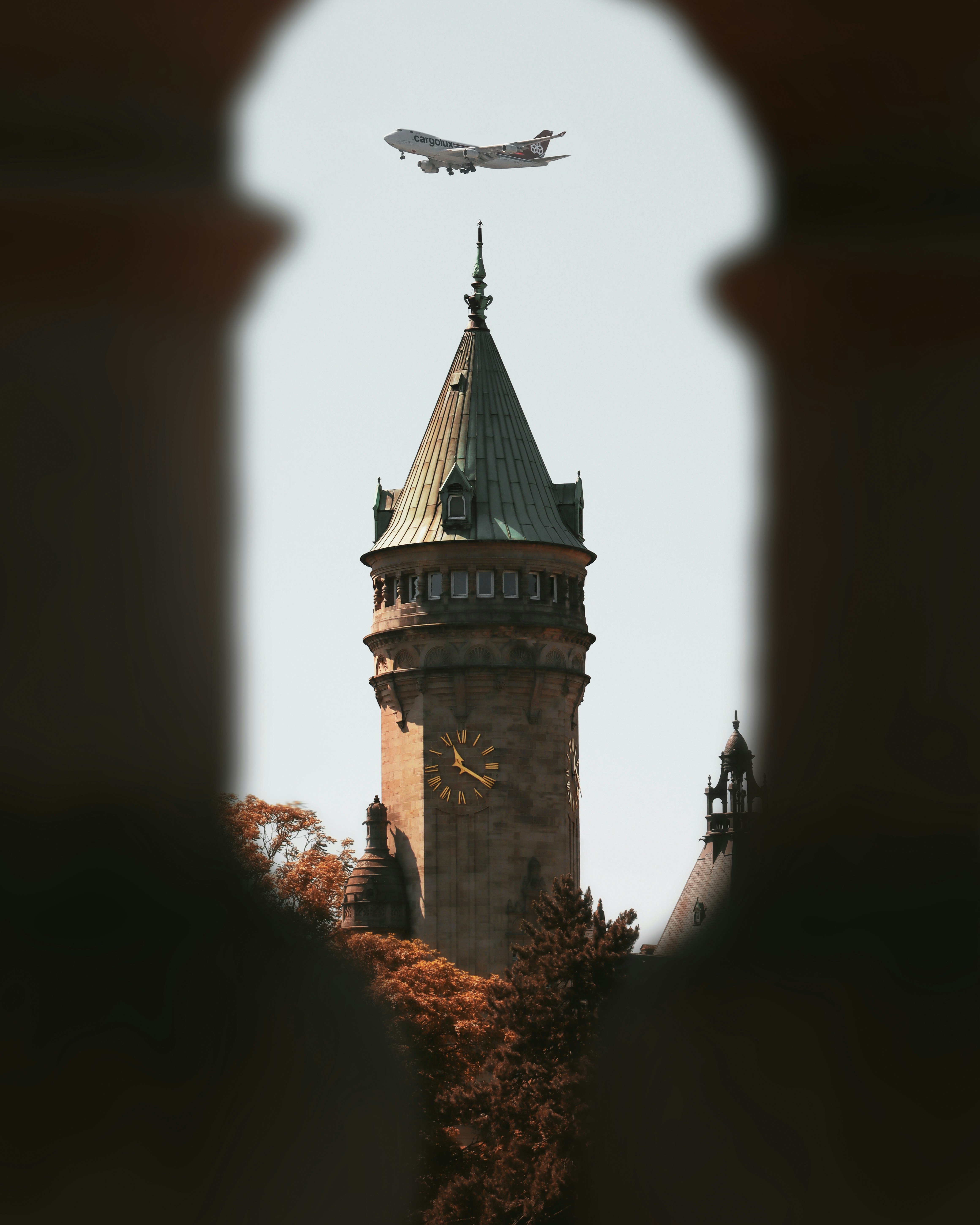 Jet Over the Clock Tower, Framed by a Shadowed Arch