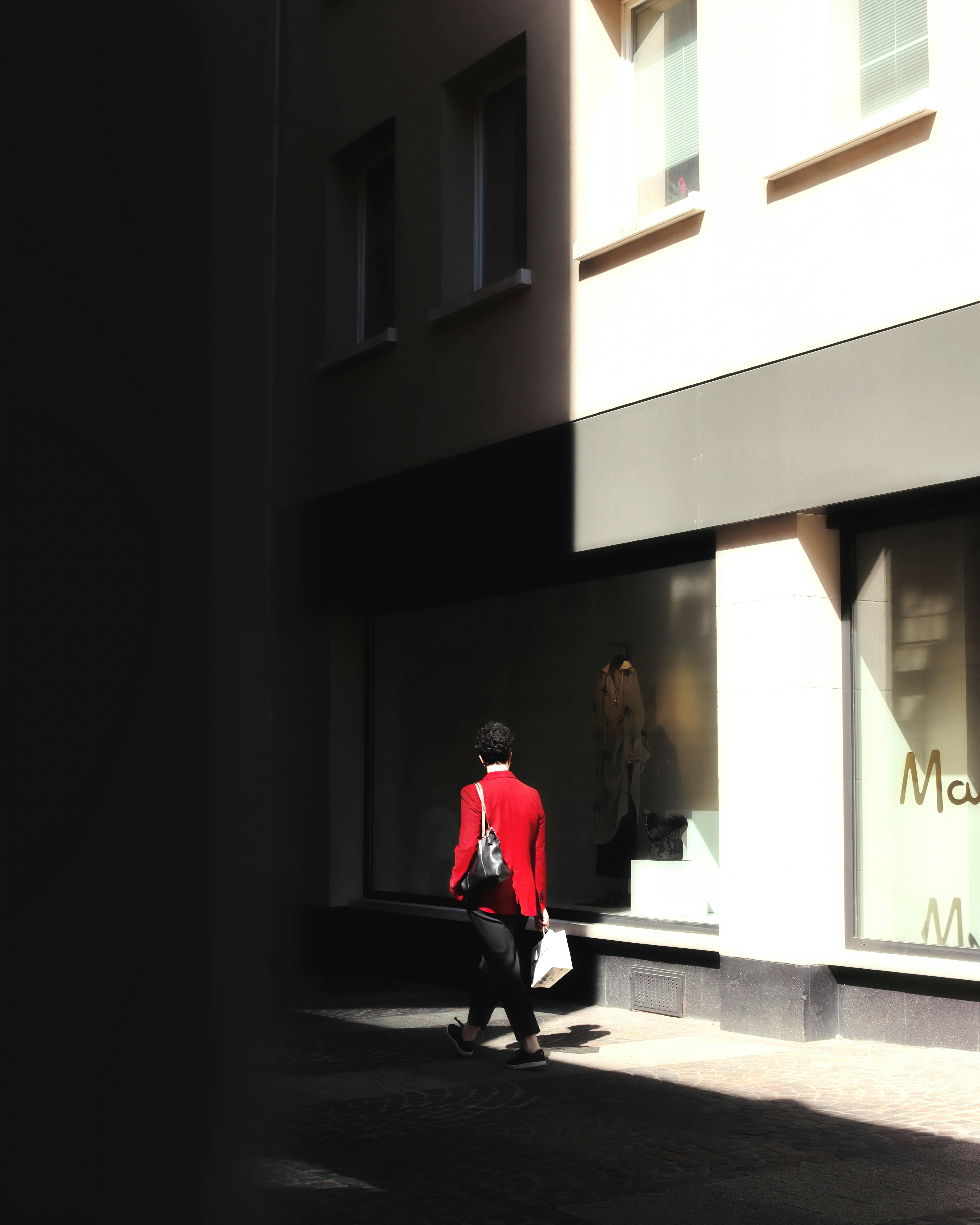 Crimson Jacket, Quiet Geometry: A Street Moment in Light