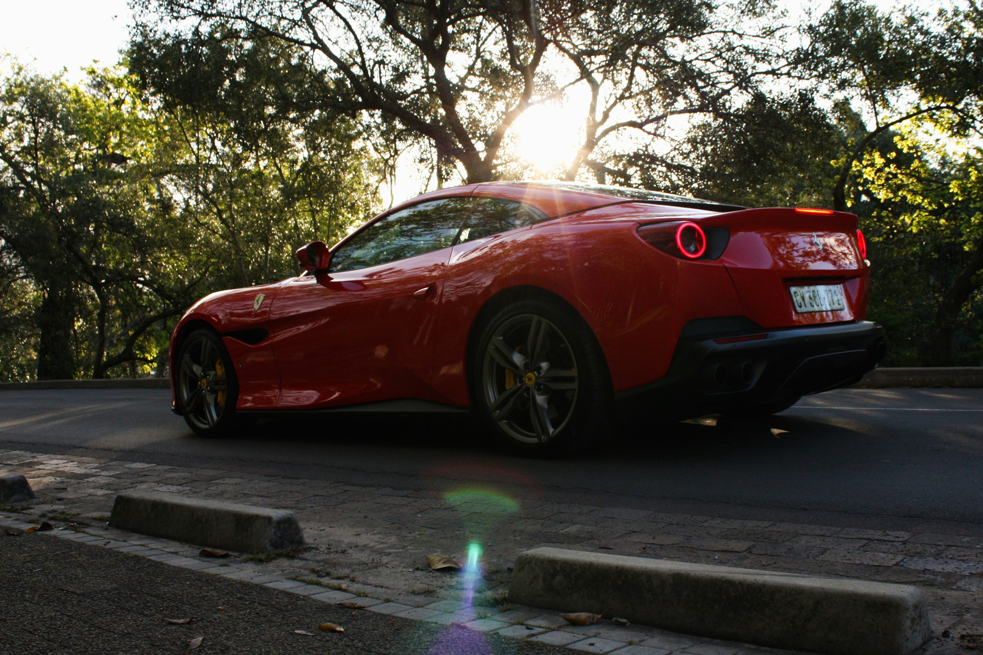 A red sports car driving down a street