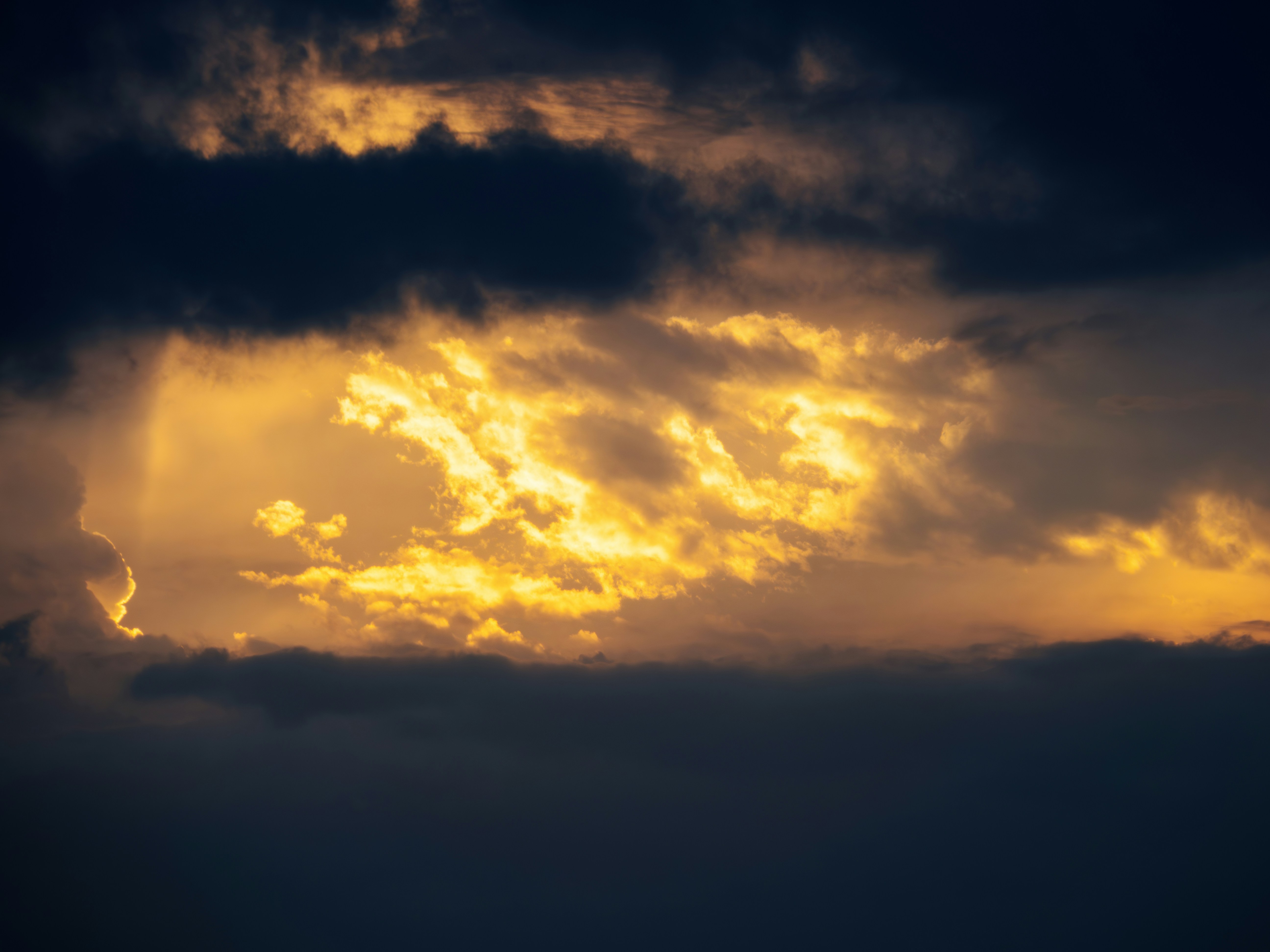 The sun is shining through the clouds in the sky