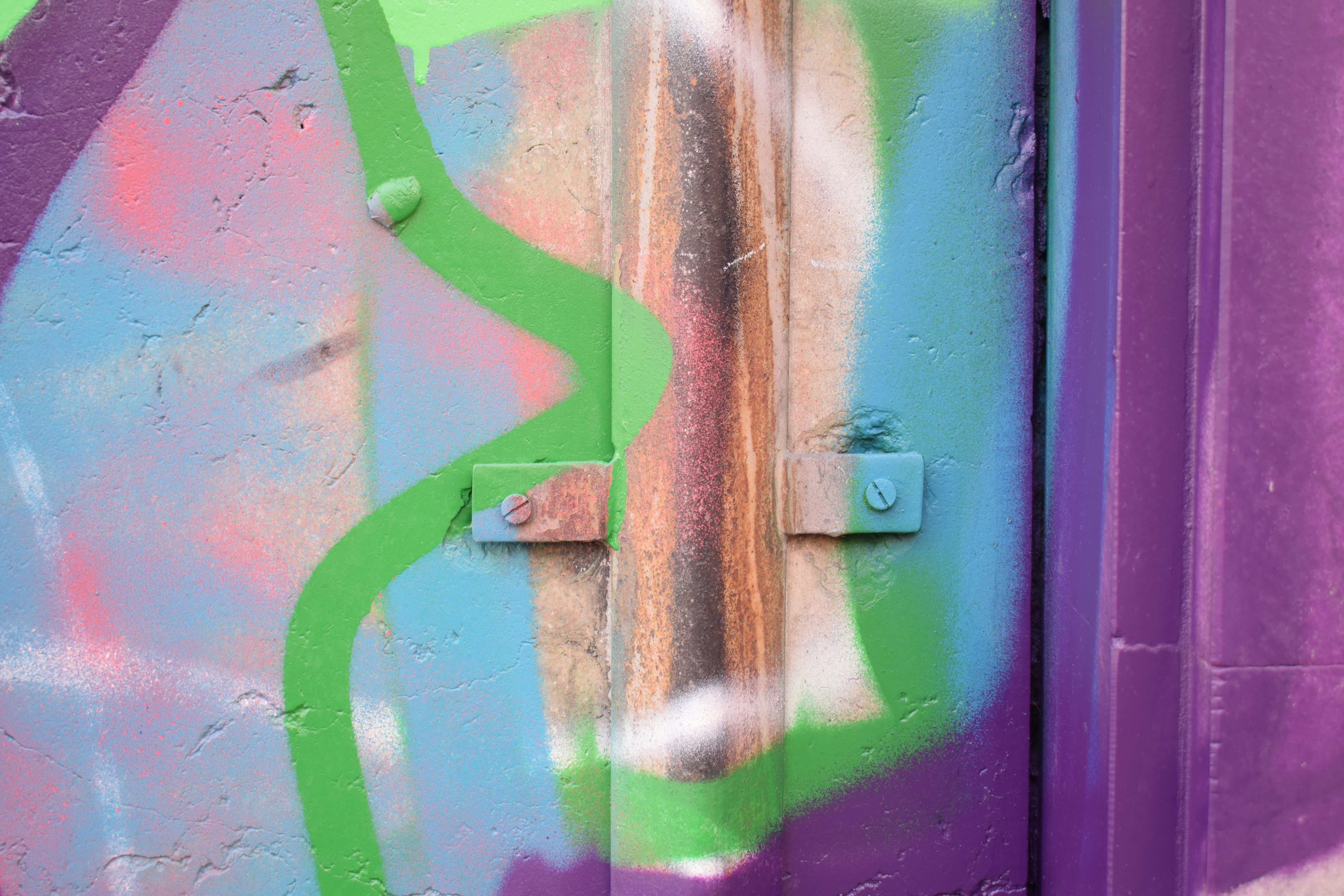 Emerald S-Curve Across a Multicolored Metal Door