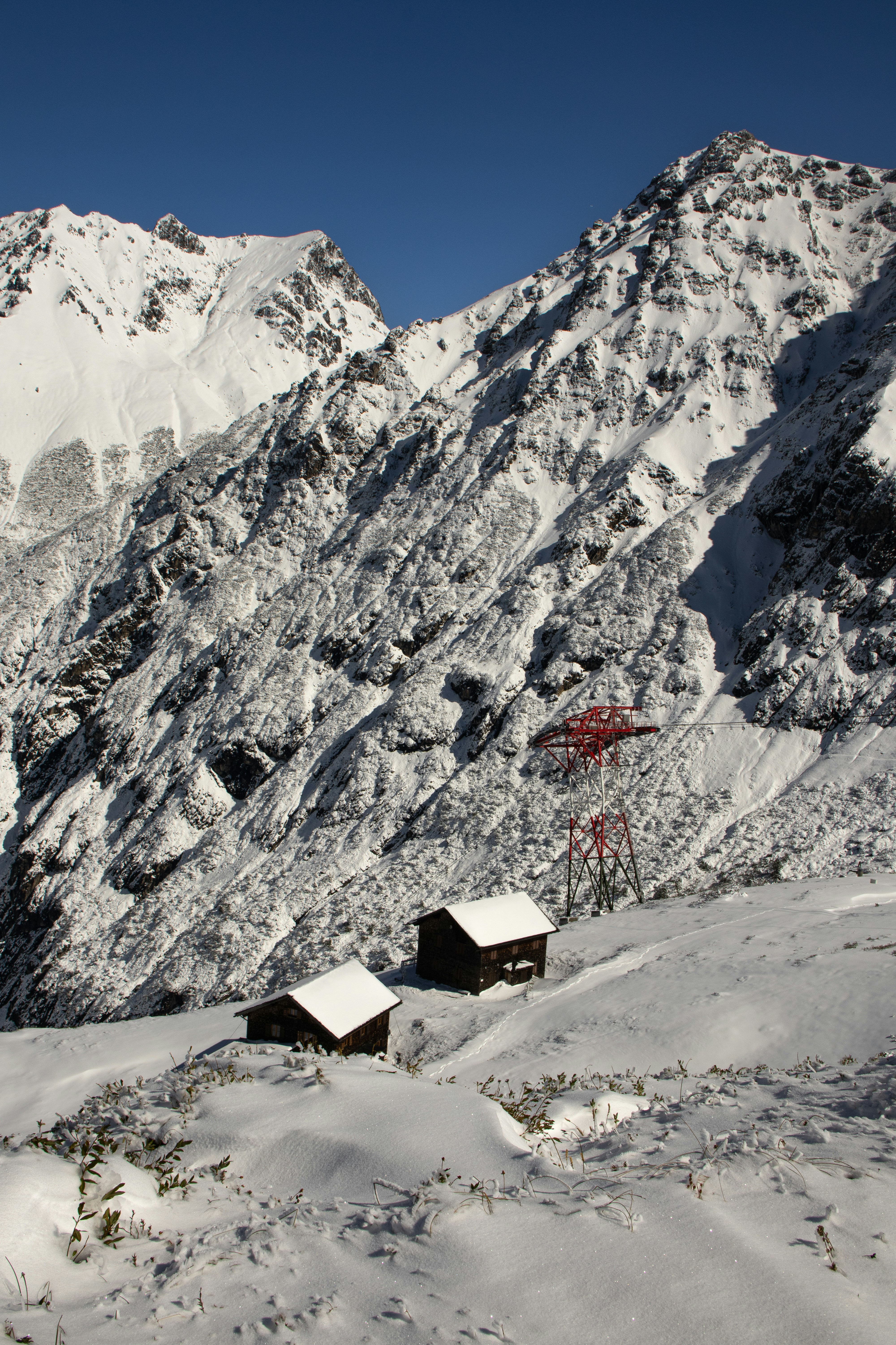 Snowbound Cabins at the Foot of Jagged Alpine Peaks