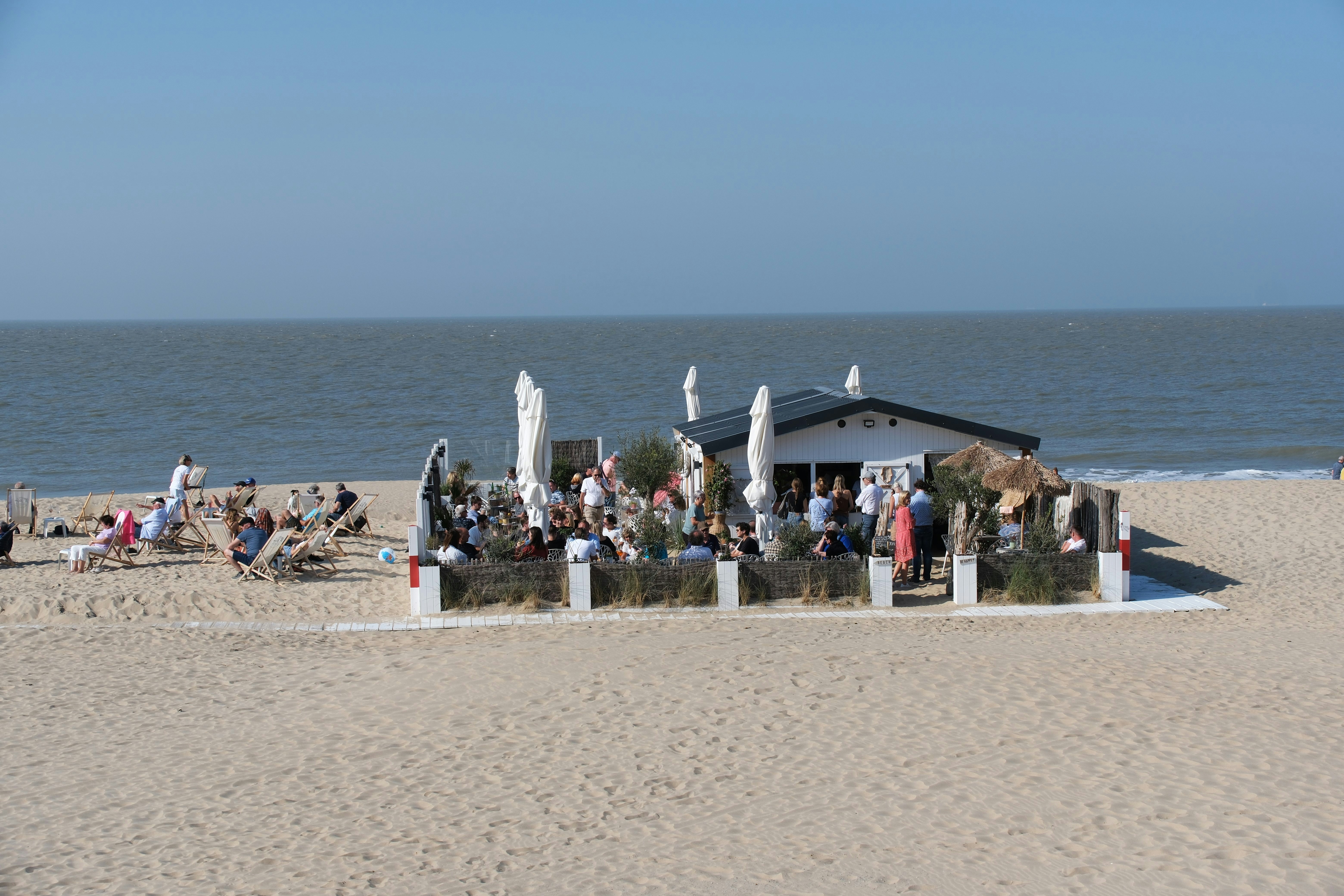 Sunlit Beach Club Pavilion Framed by White Parasols