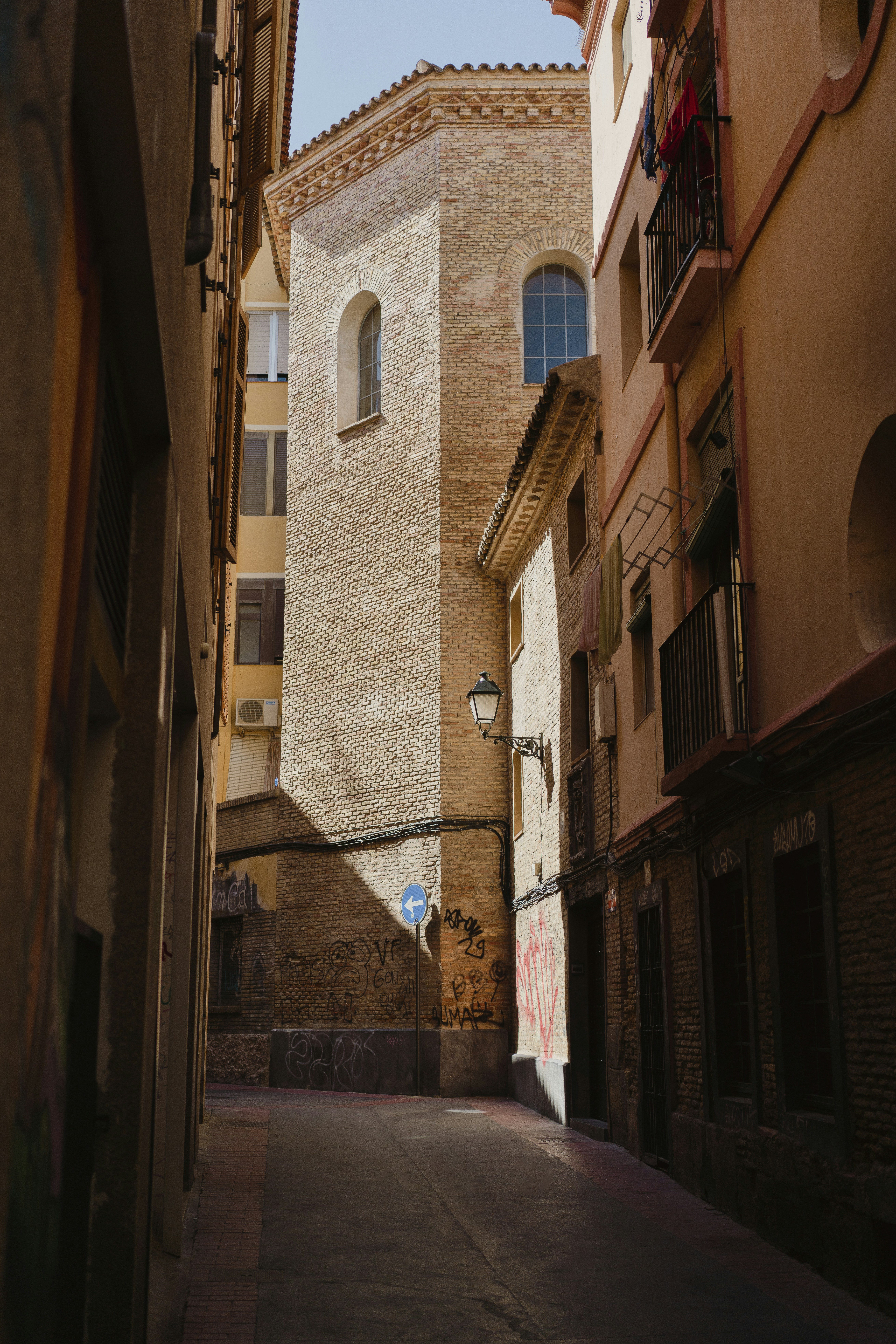 A narrow alley with a clock tower in the background photo – Free ...