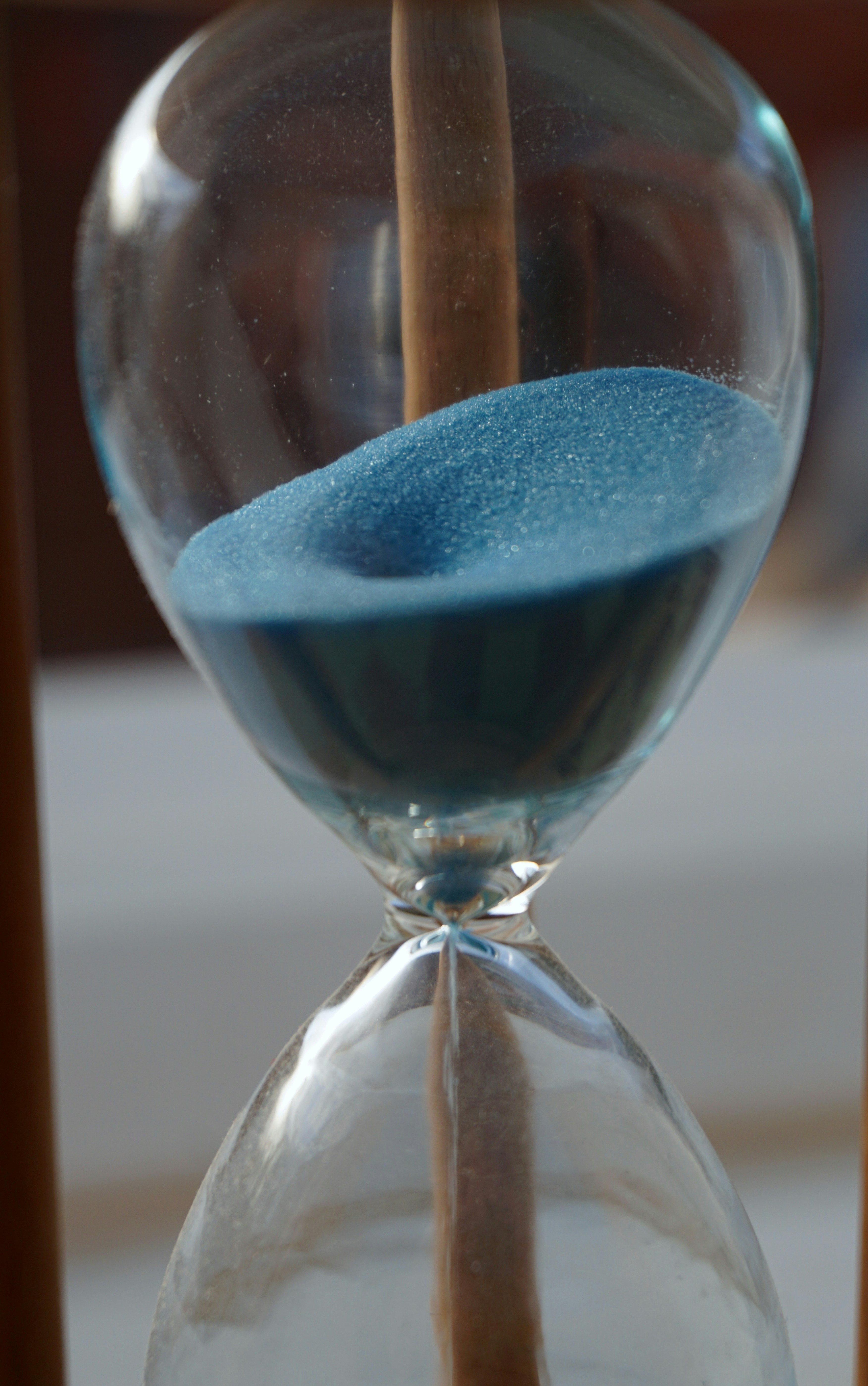 An hourglass with a blue sand inside of it photo – Free Hourglass Image ...