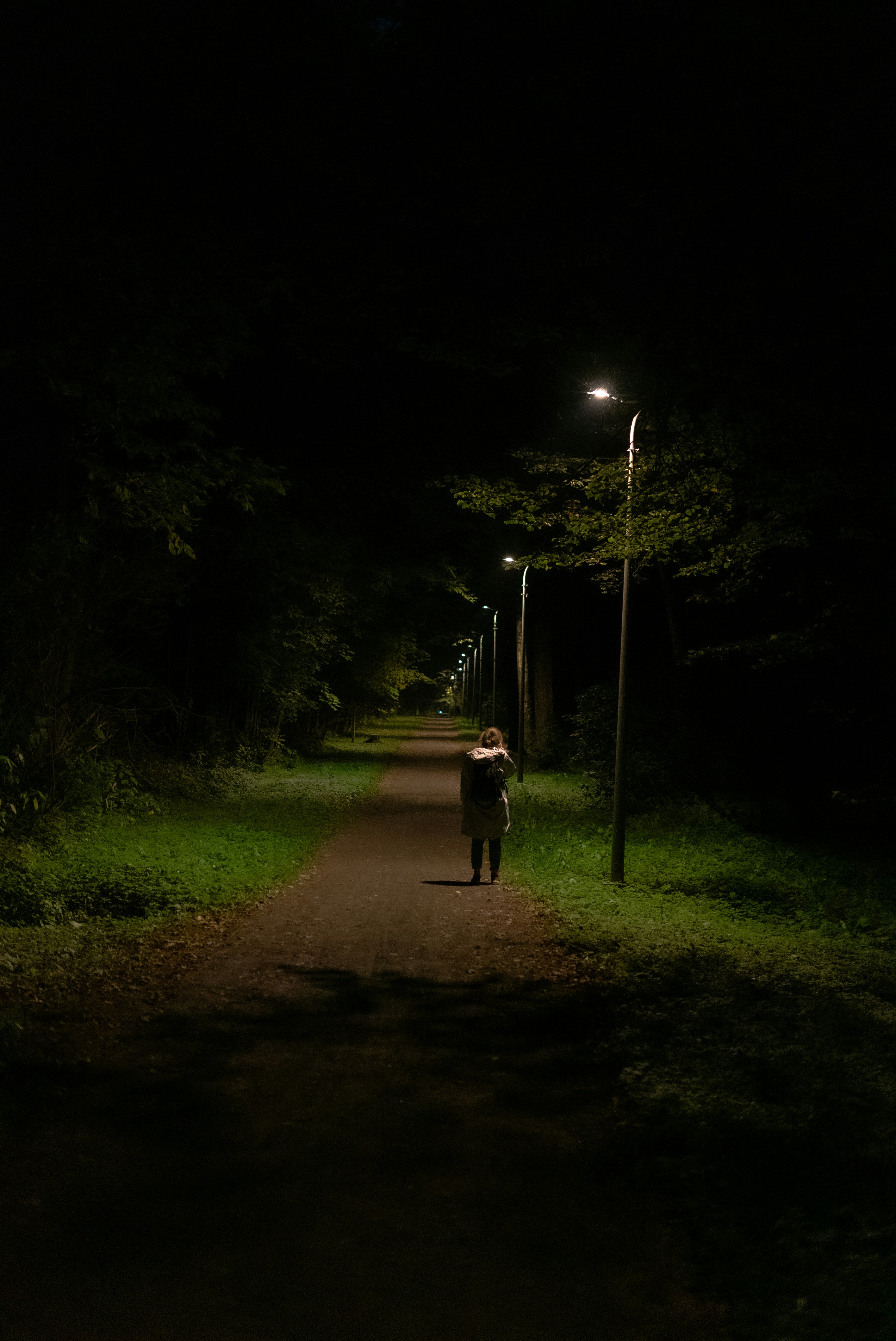 A person walking down a path at night photo – Free Road Image on Unsplash