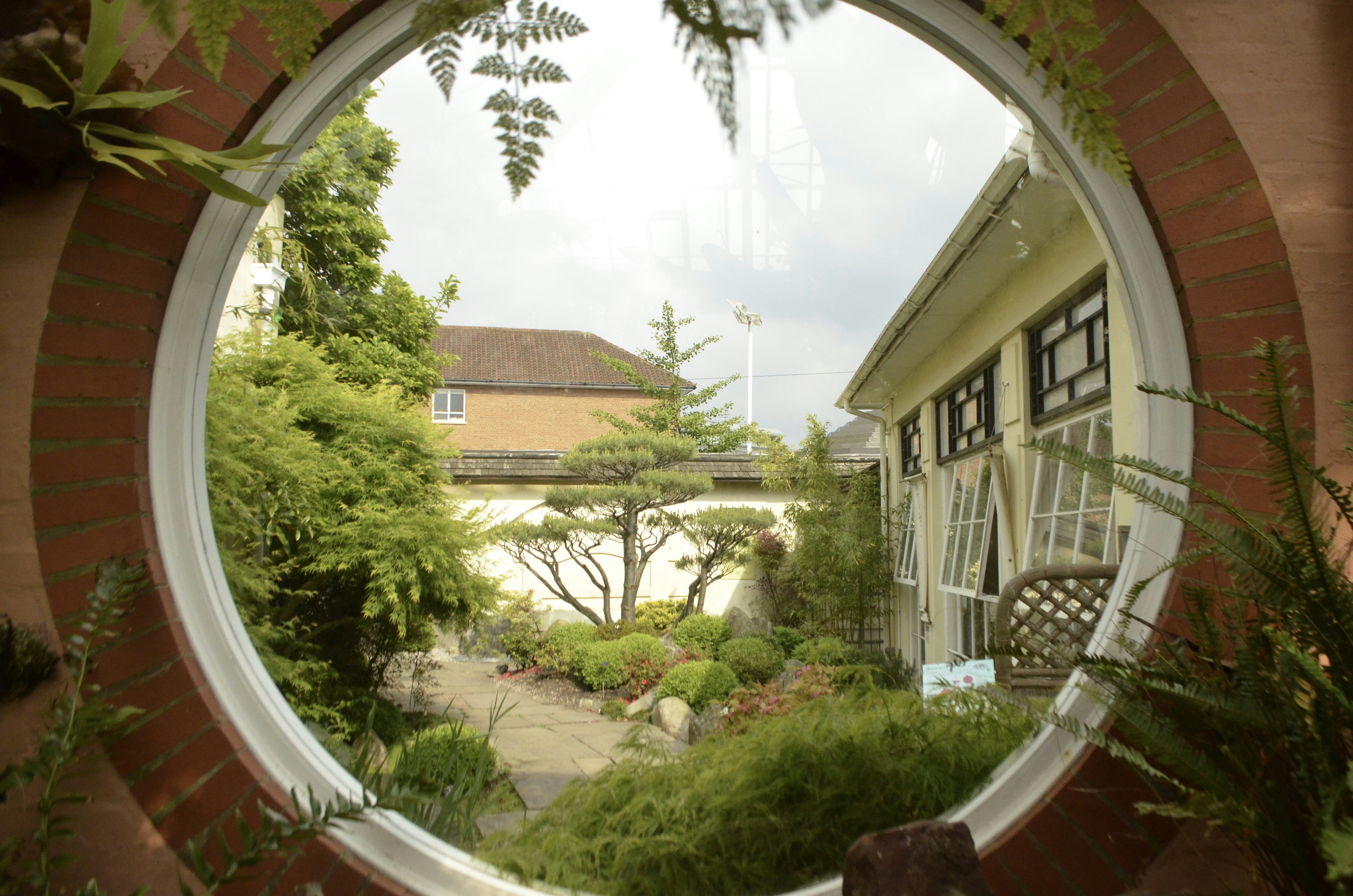 A view of a house through a circular window photo – Free Photo Image on ...