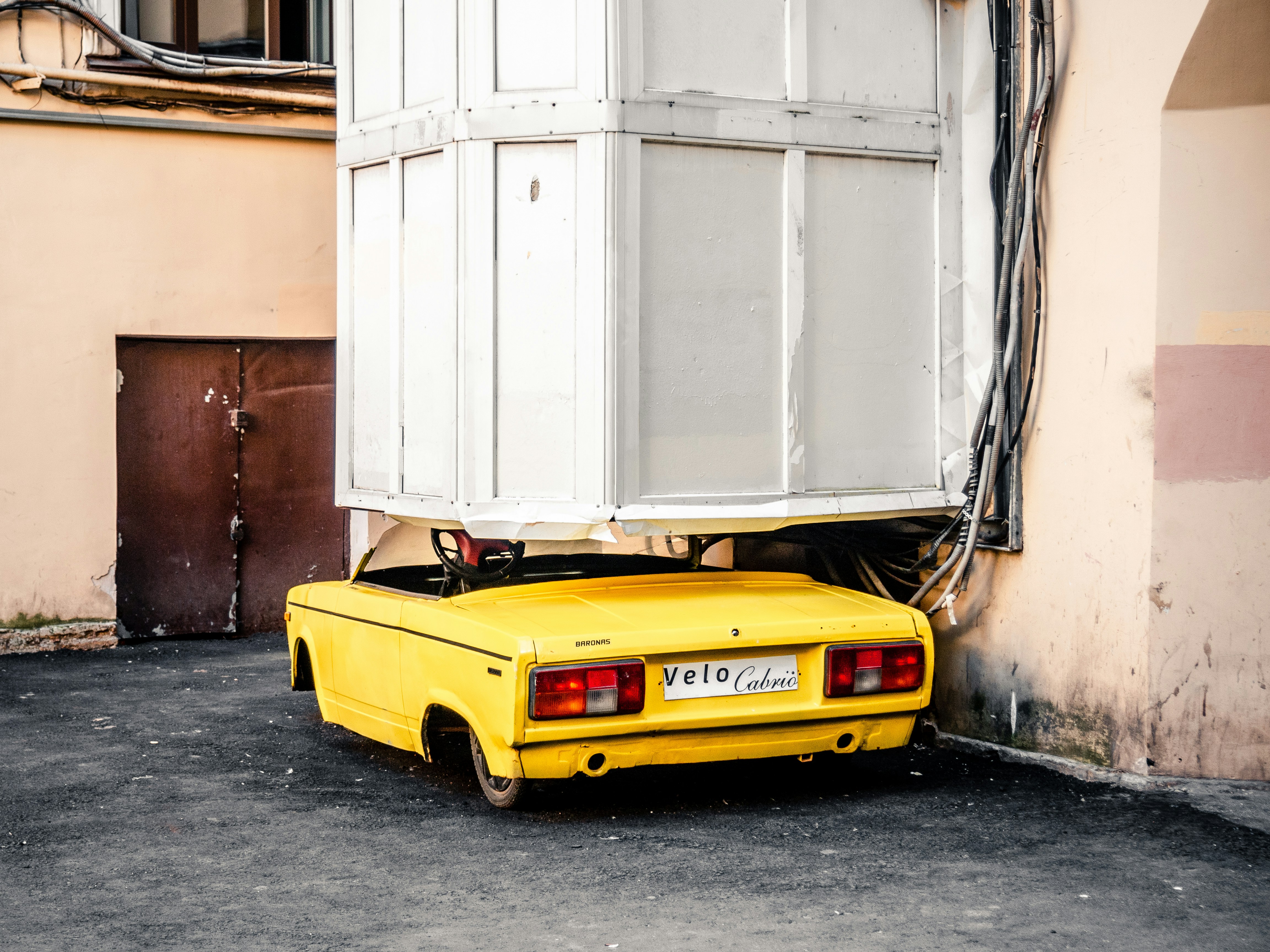 Yellow Cabrio Beneath a Boxy White Overhang: A Surreal Urban Car-Scape
