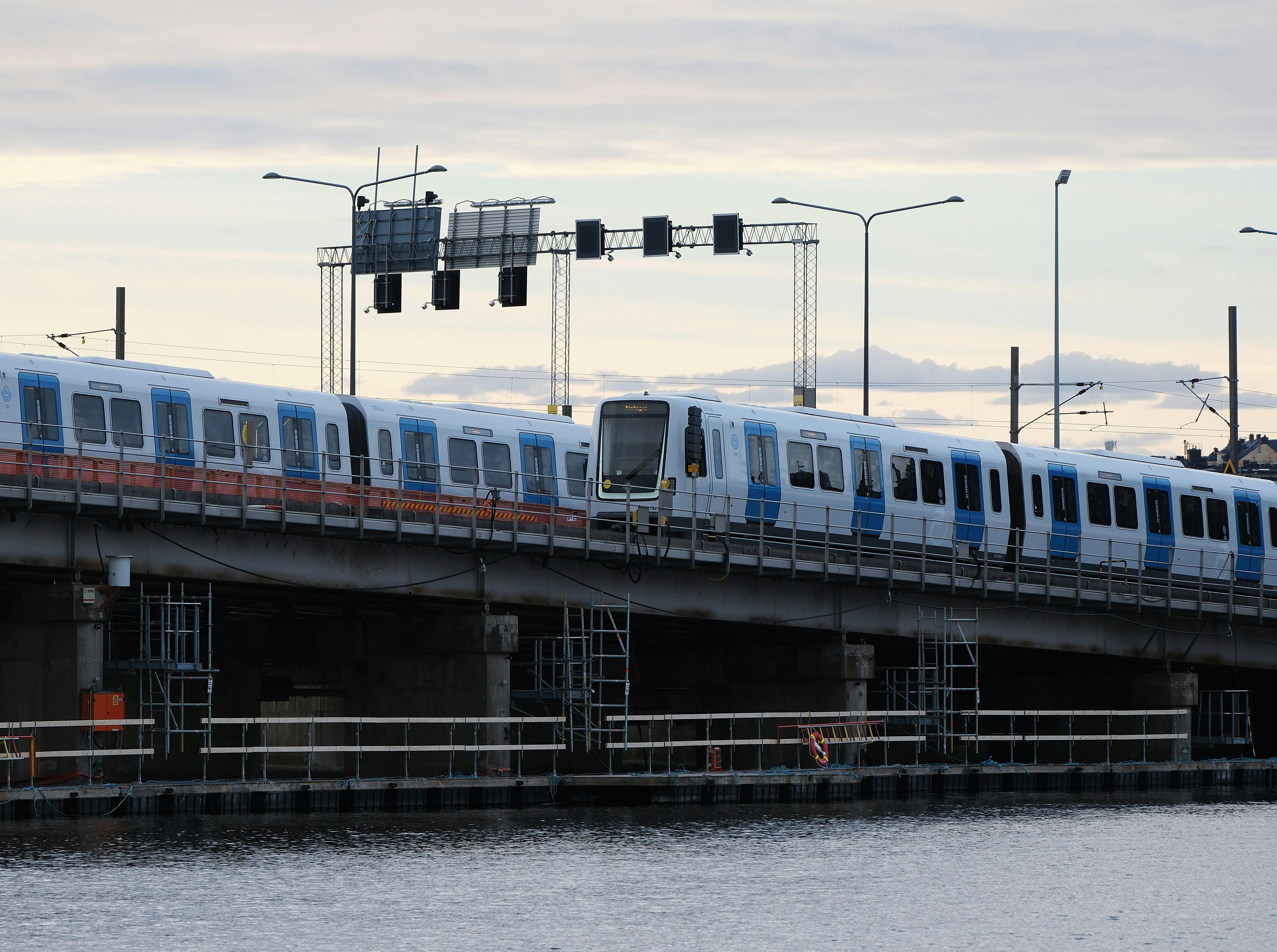Blue-White Transit Over the Harbor Bridge at Dusk
