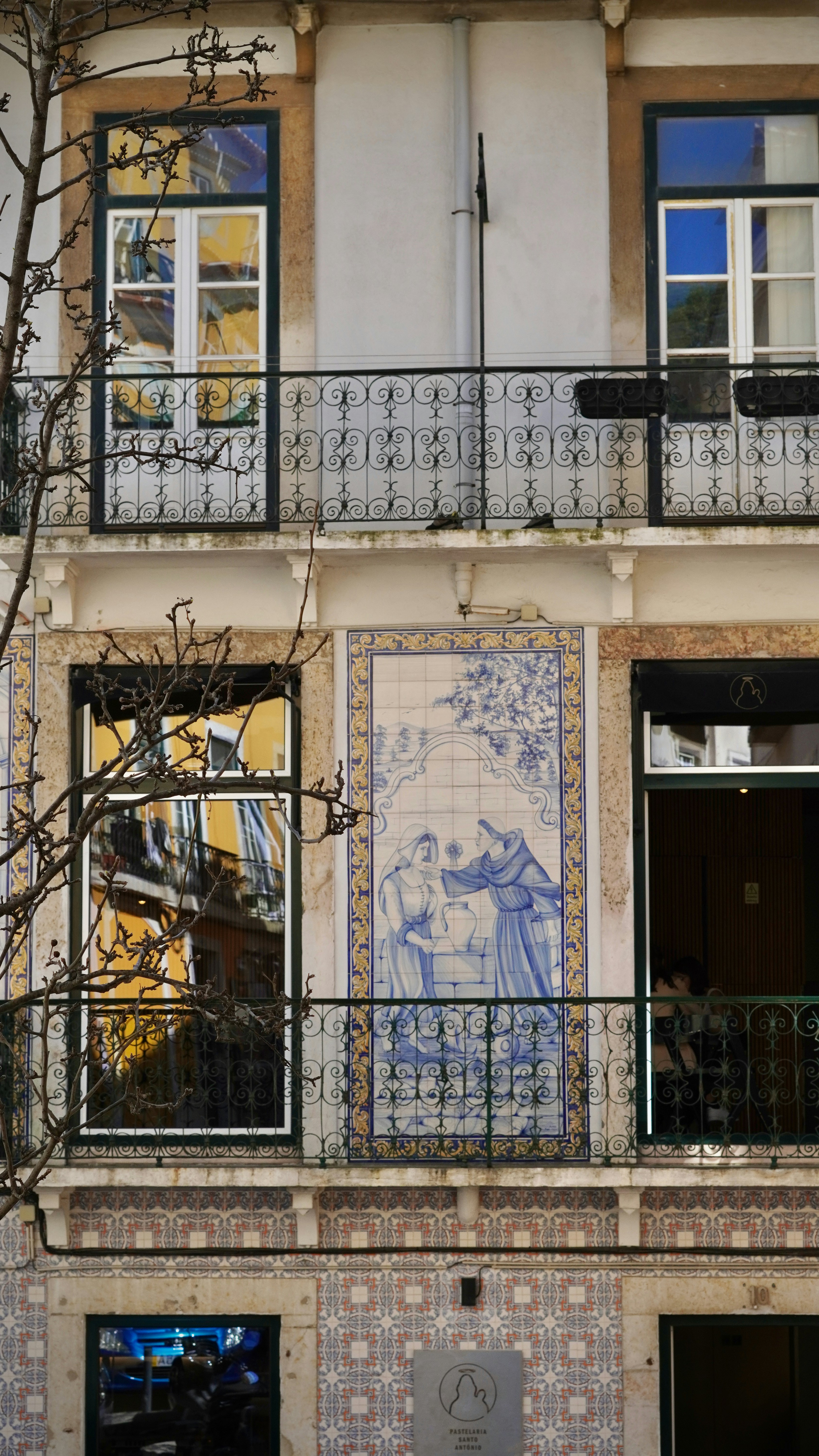 Blue-and-White Tile Mural Framed by Balcony Railings