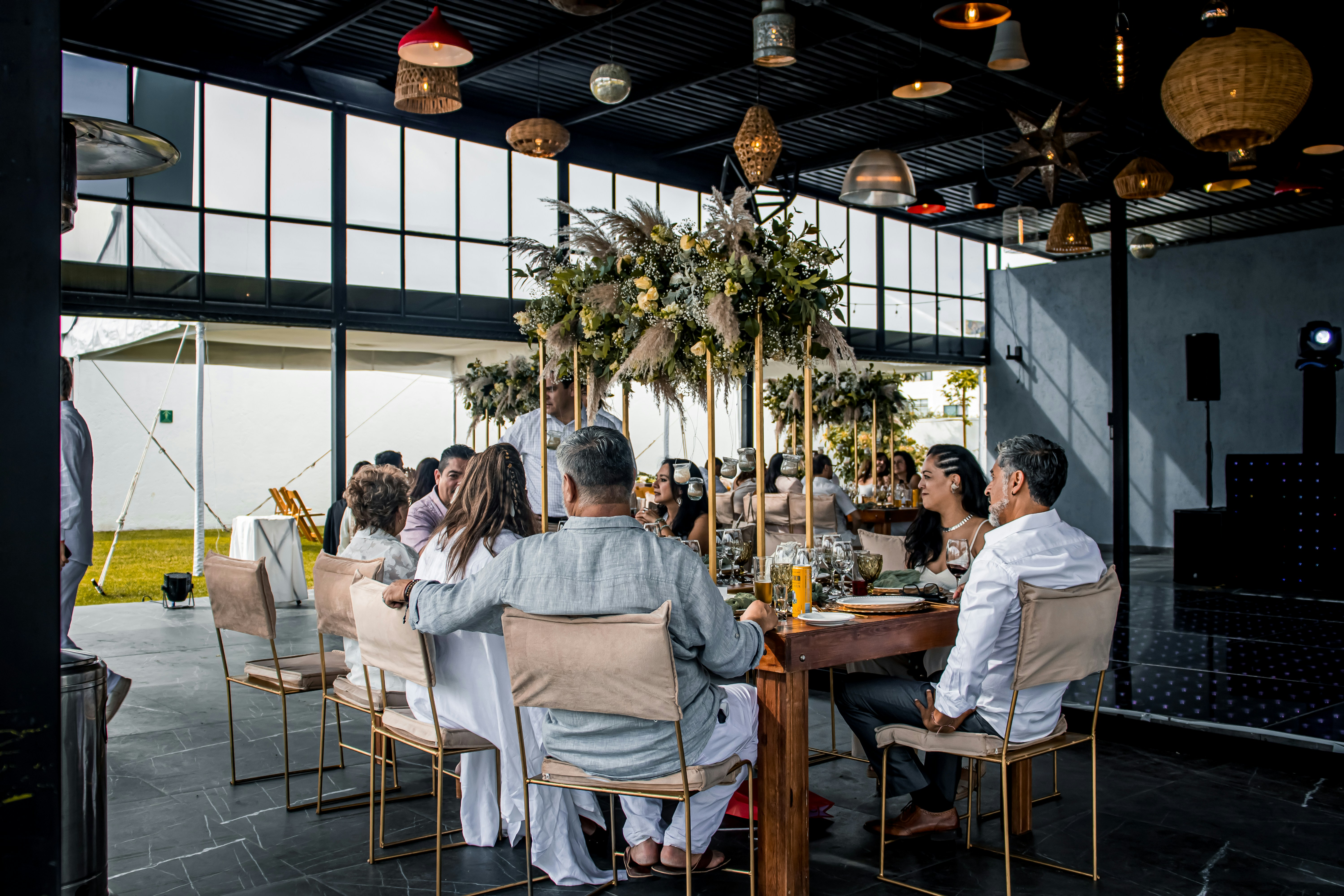 Loft Banquet Under Amber Lanterns: A Floral Arch Dinner Crowd