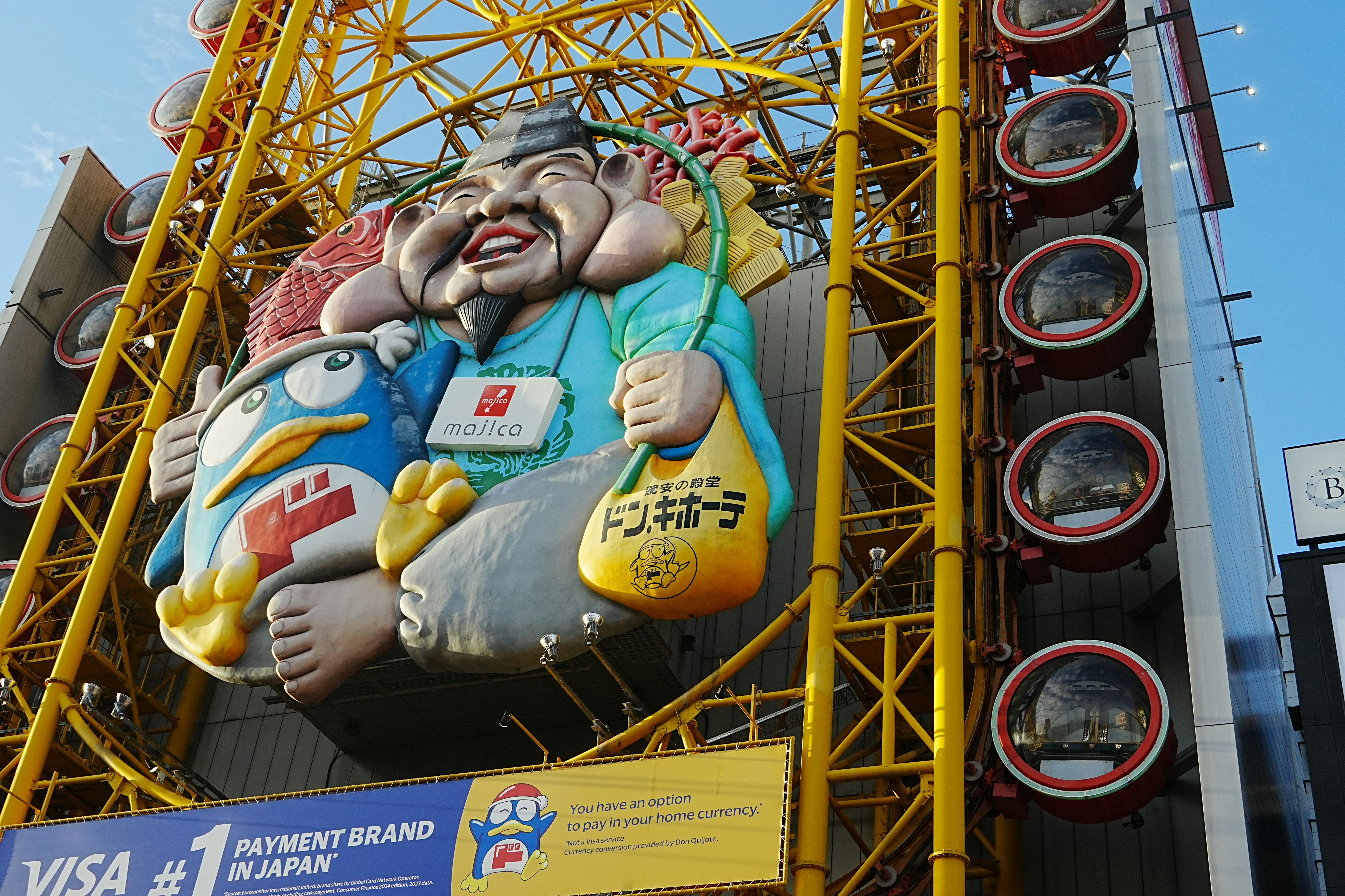 A large statue of a man on top of a roller coaster photo – Free Japan ...