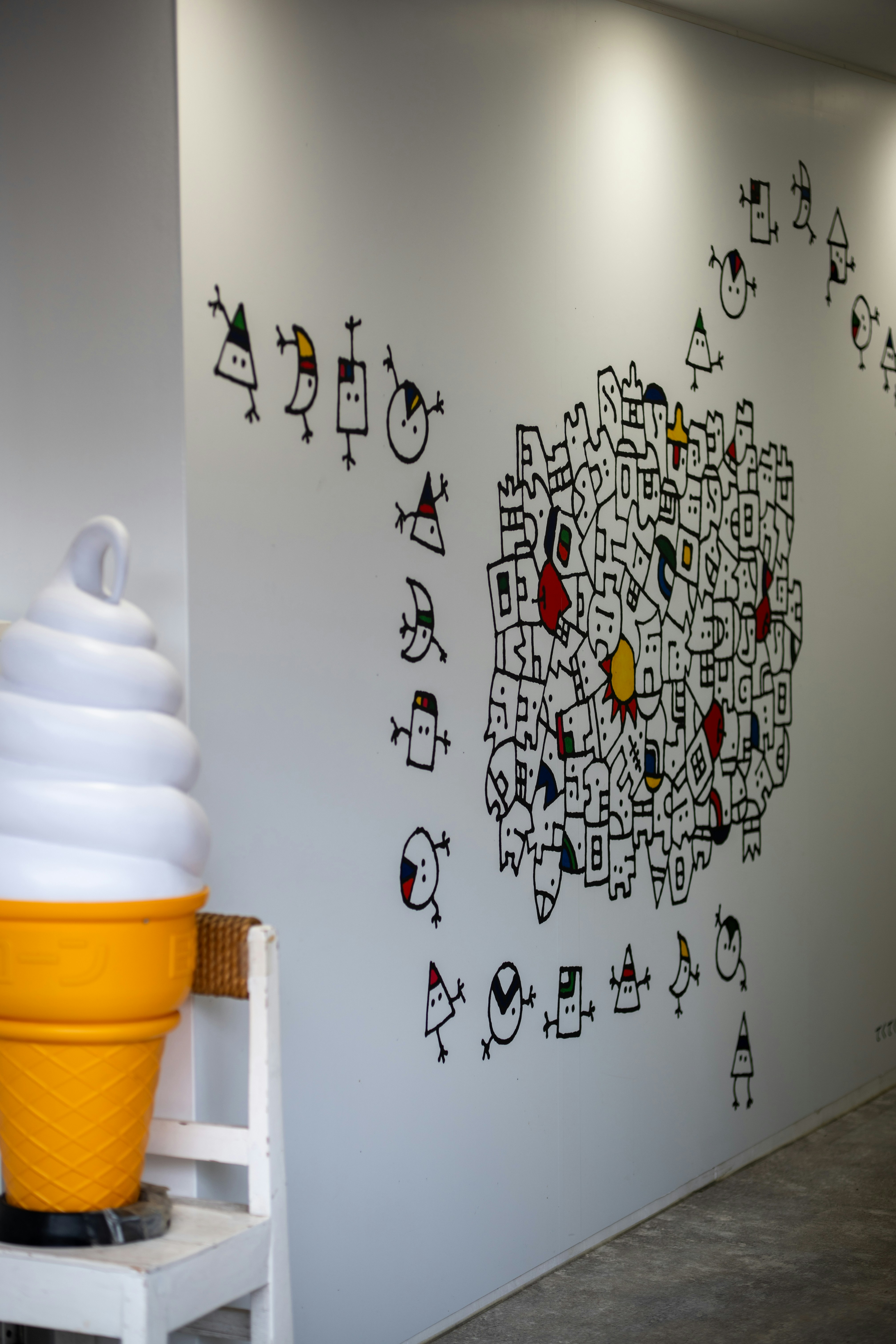 Doodle Cityscape Unfolds Across a White Wall, Anchored by a Giant Ice-Cream Cone