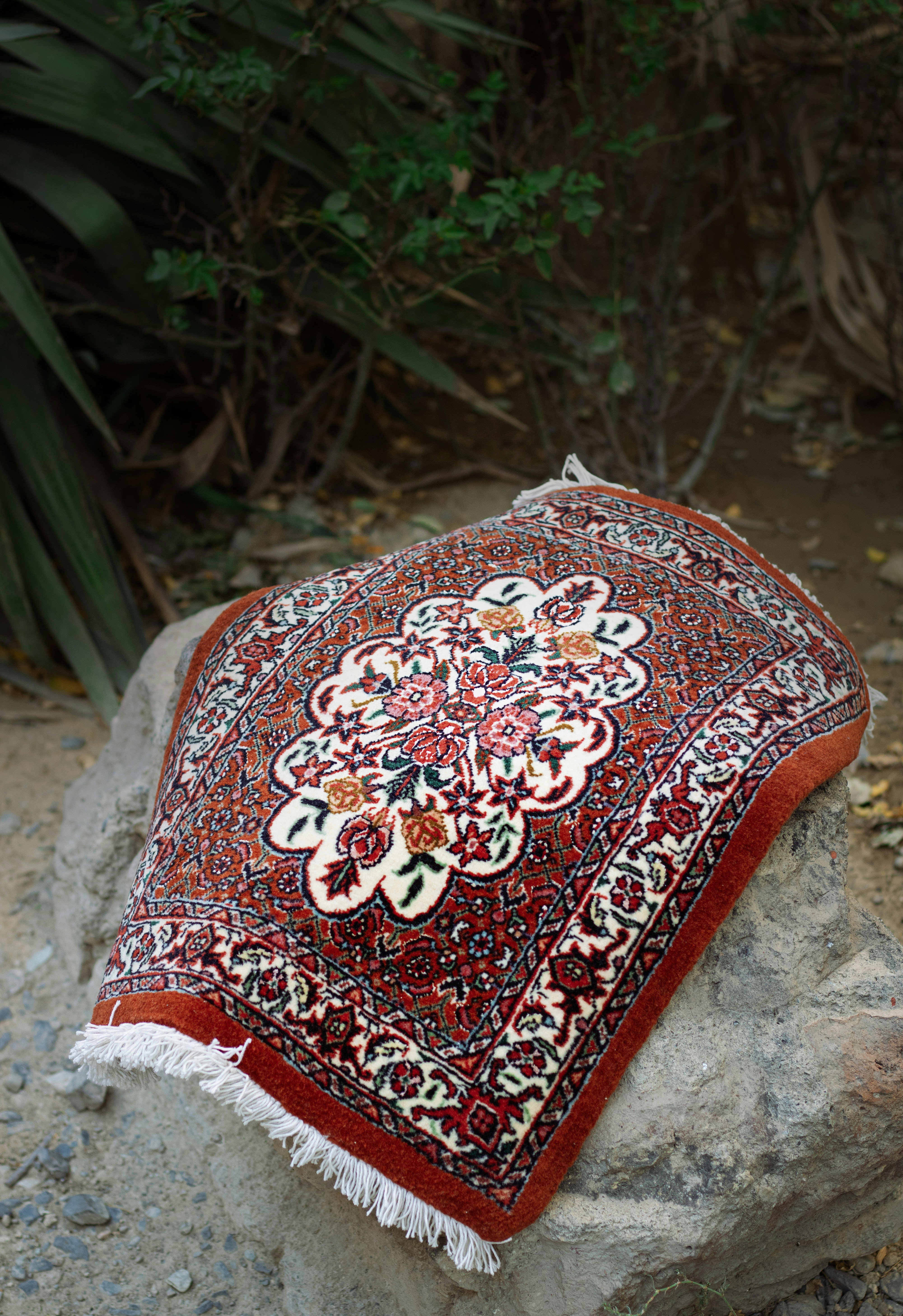 Crimson Rose Medallion Draped Across a Weathered Stone