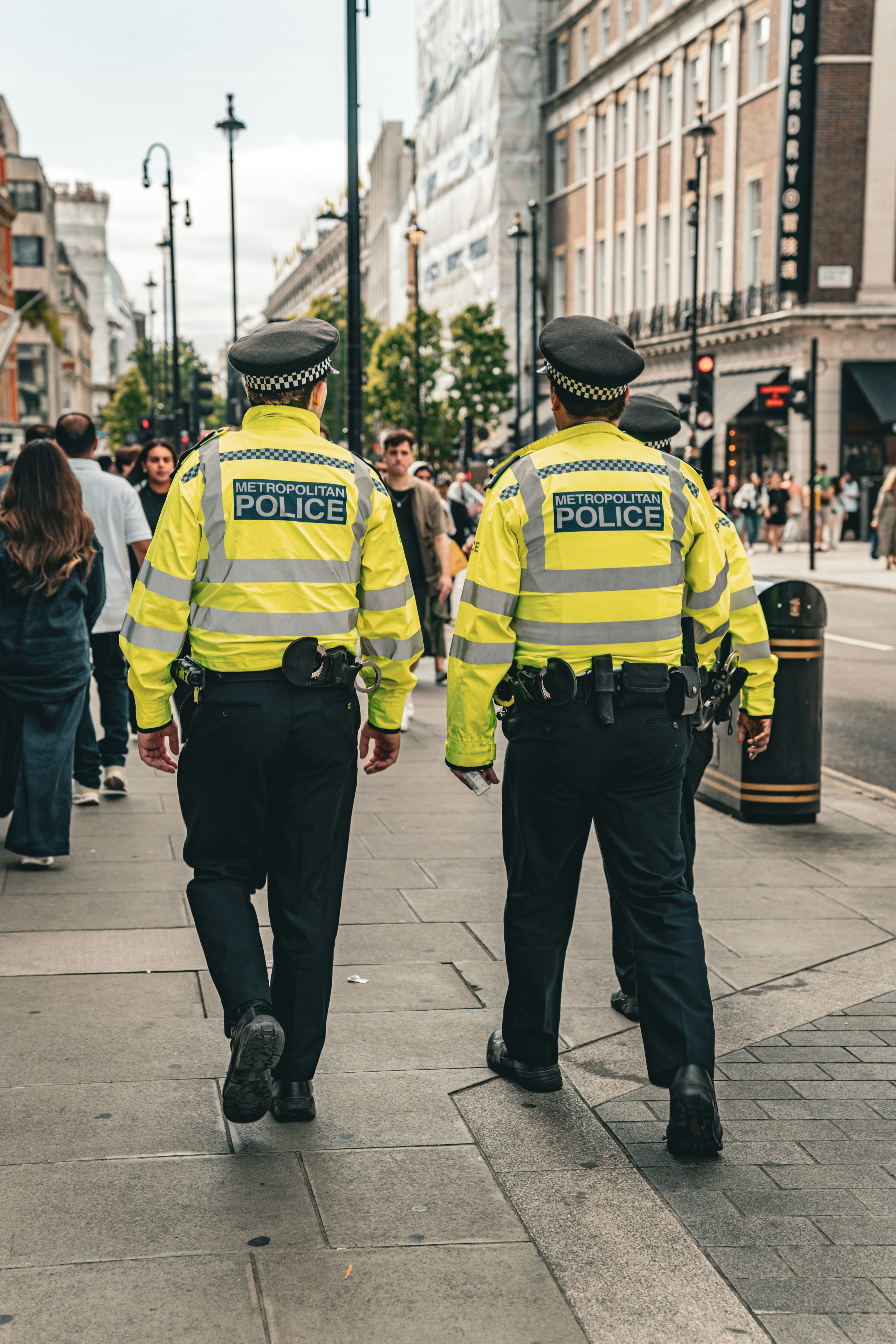 Two police officers walking down a city street photo – Free Building ...