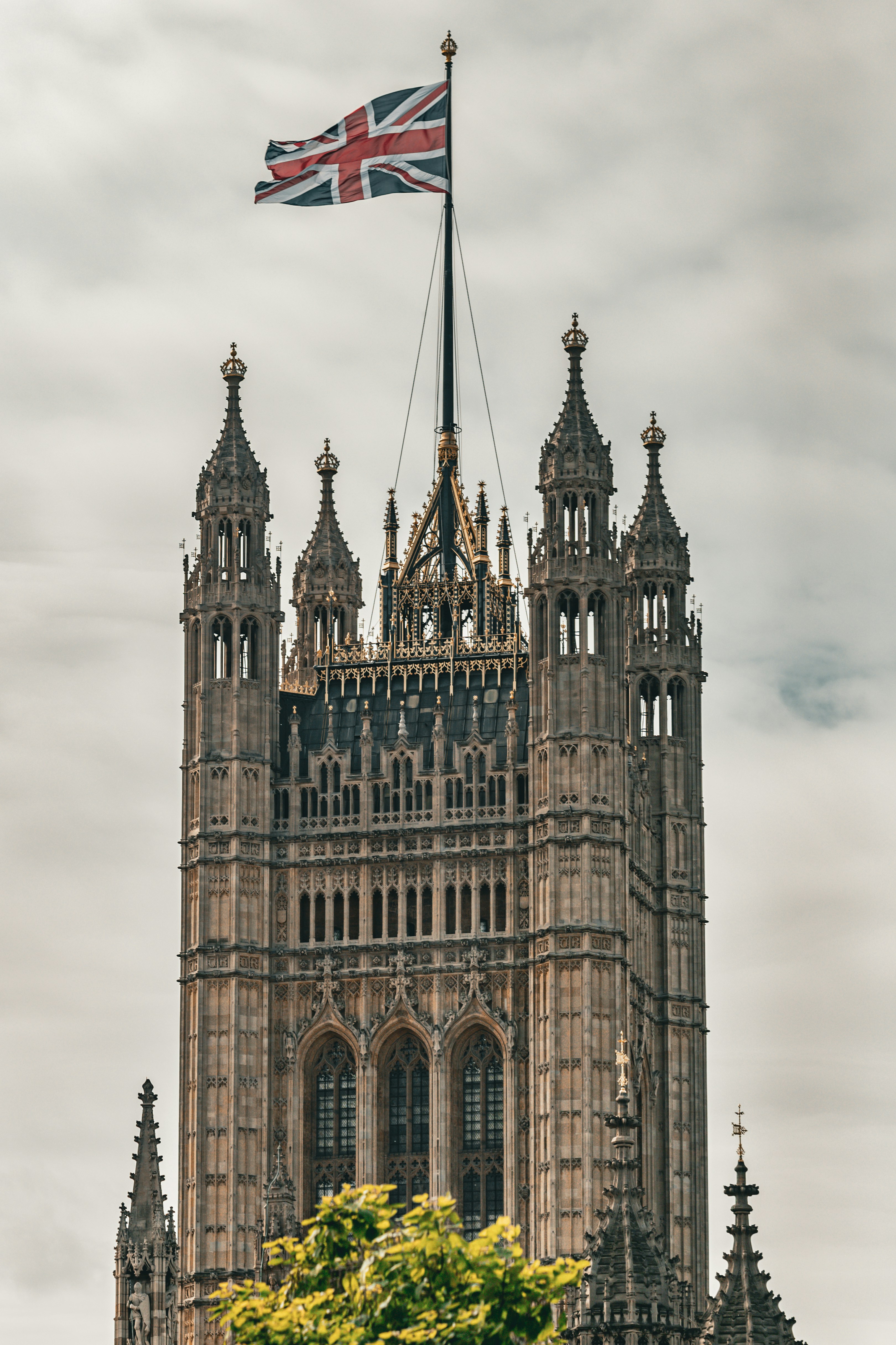 Flag at Westminster's Crown: Gothic Spires Reach Toward a Cloudy Sky