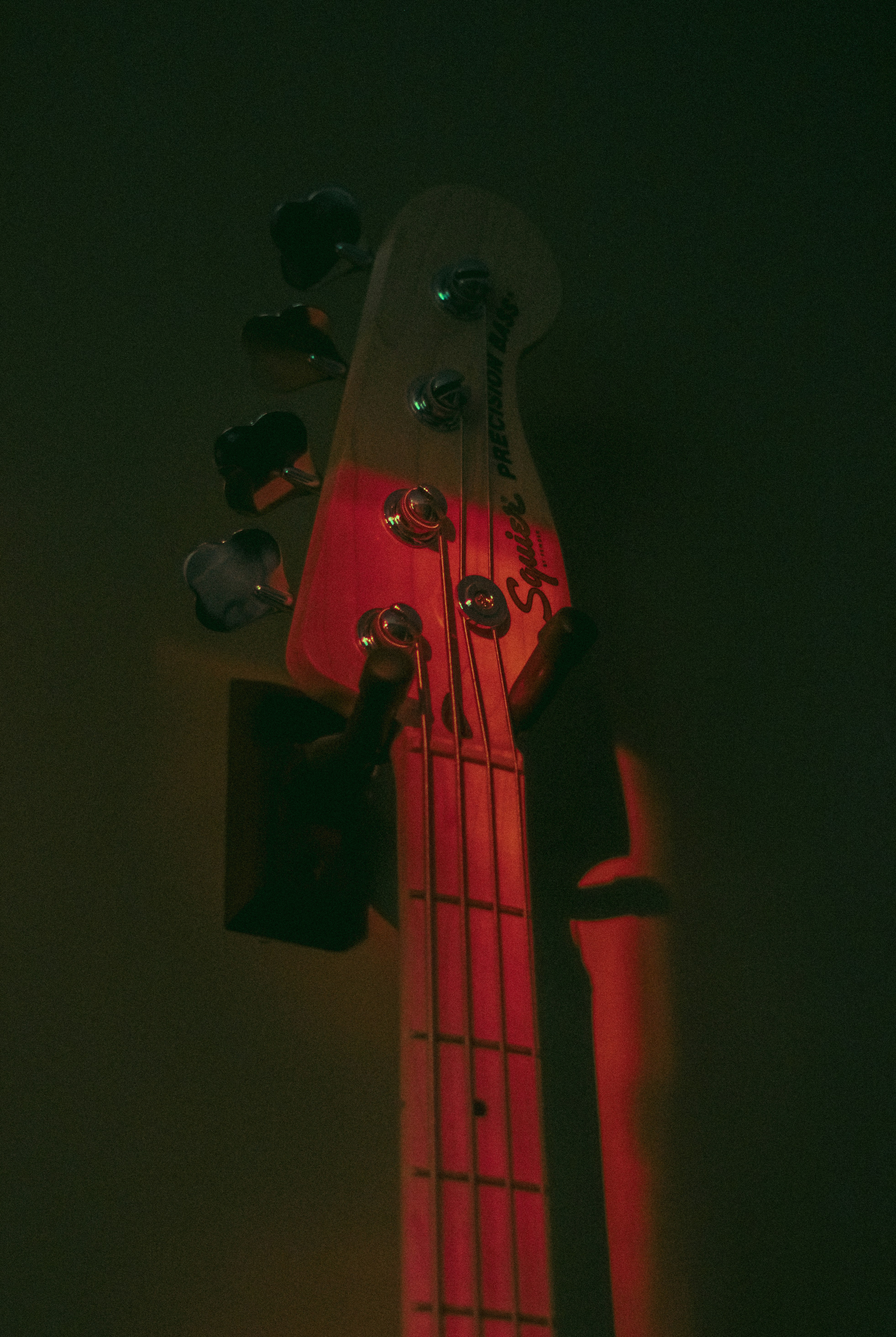Squier by Fender Under Red-Green Glow: A Headstock Portrait