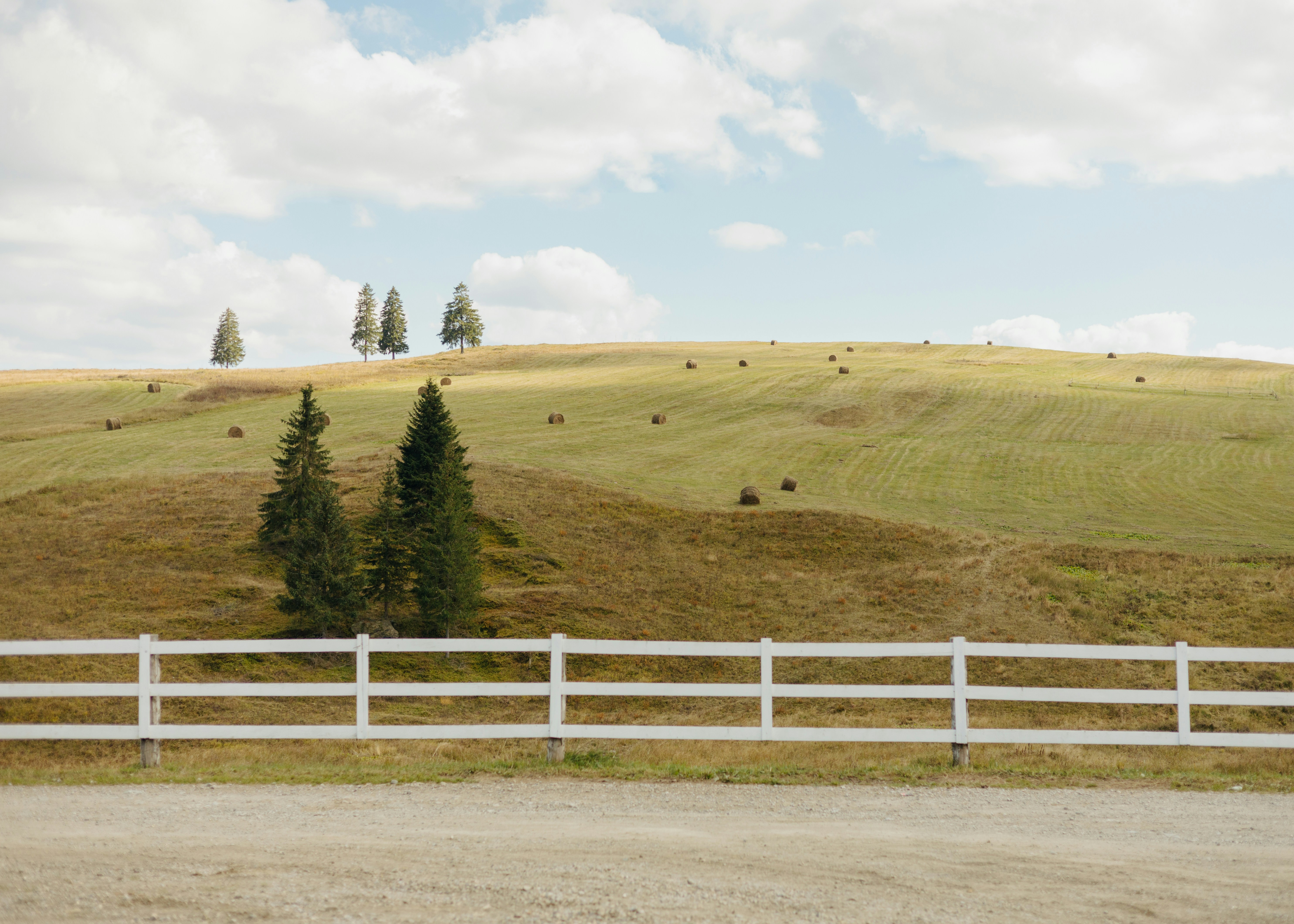 A white fence in front of a grassy hill photo – Free Romania Image on ...