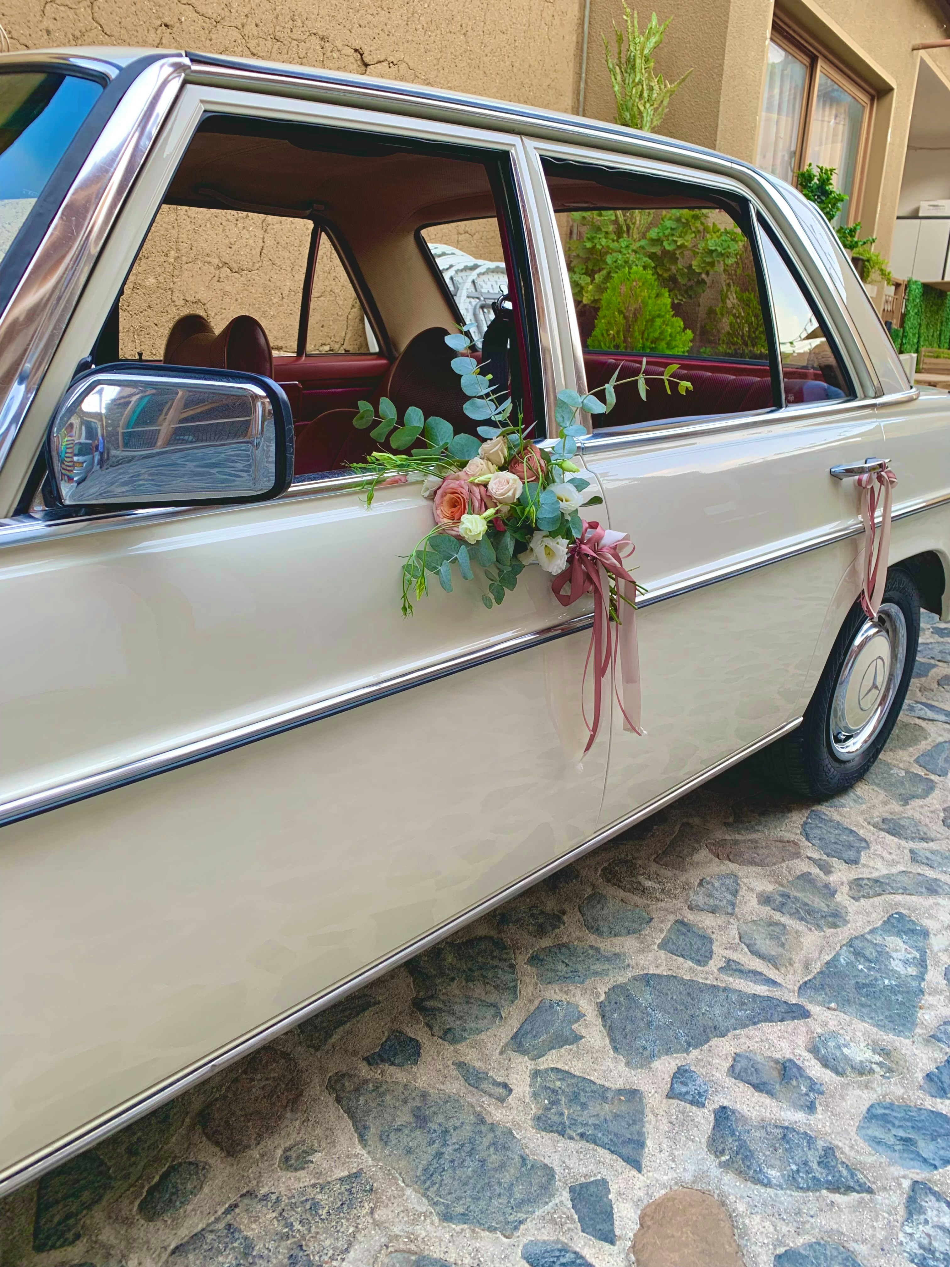 Rosy Bouquet Draped Across a Cream Classic Sedan