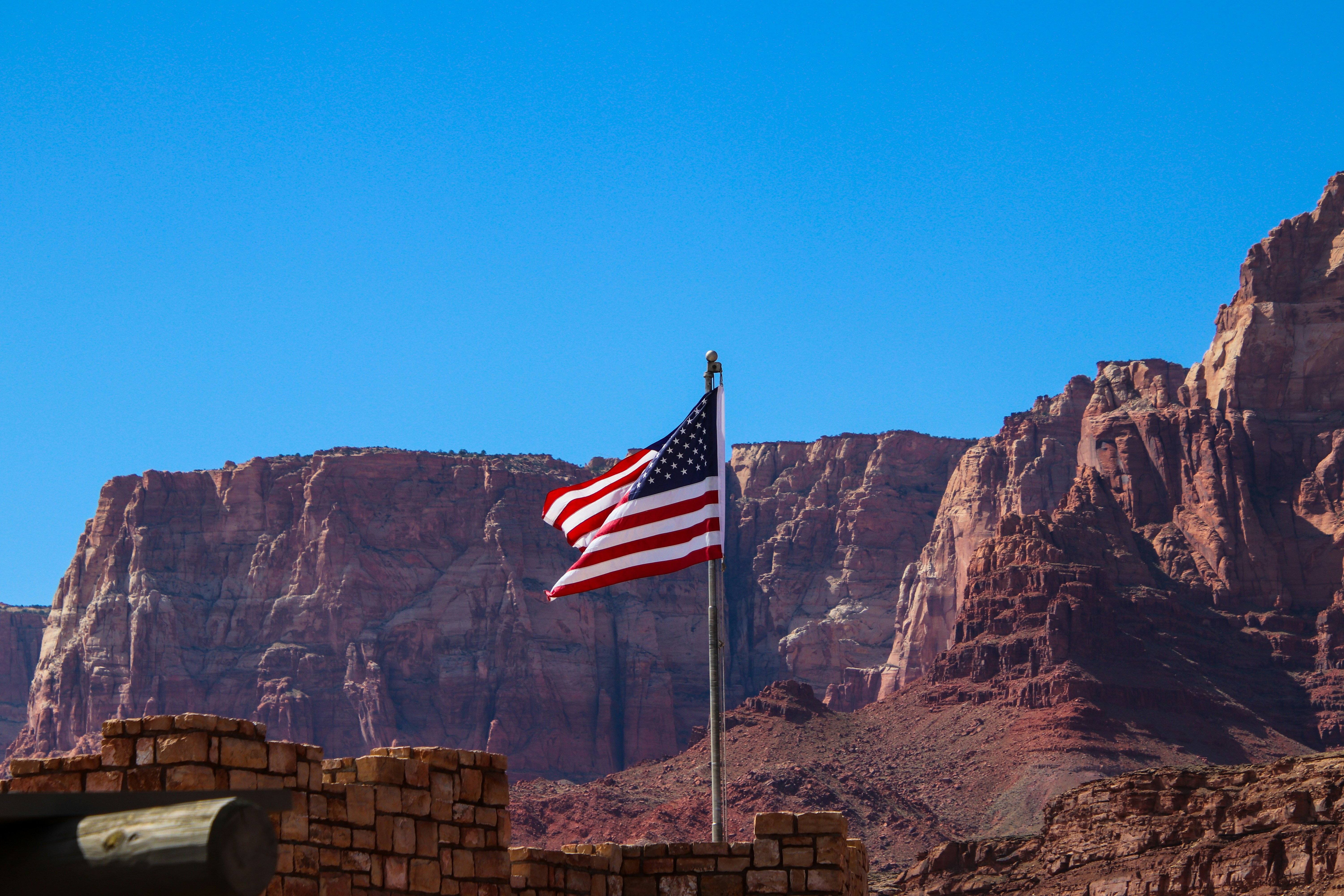 Flag Over Red Cliffs: A Quiet Moment Beneath a Clear Blue Sky