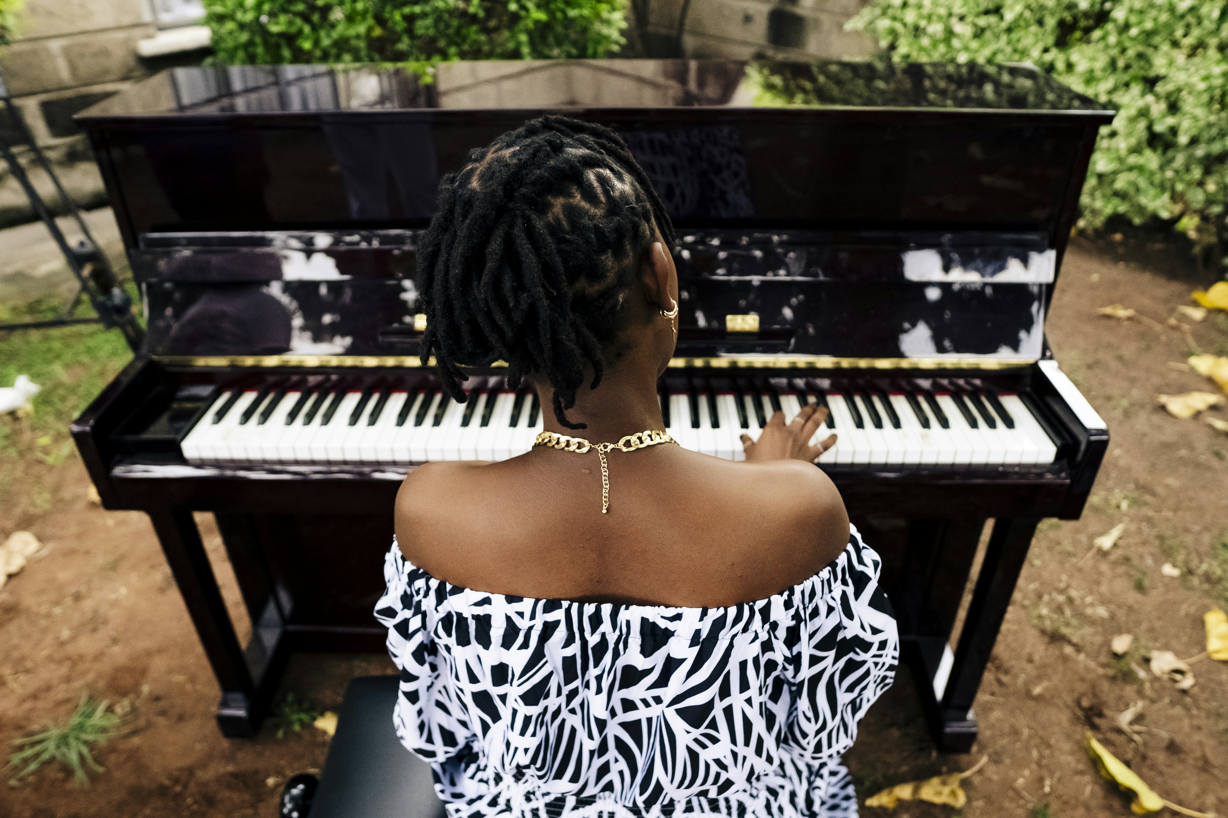 Portrait at the Keys: Back View of a Musician Playing an Outdoor Piano