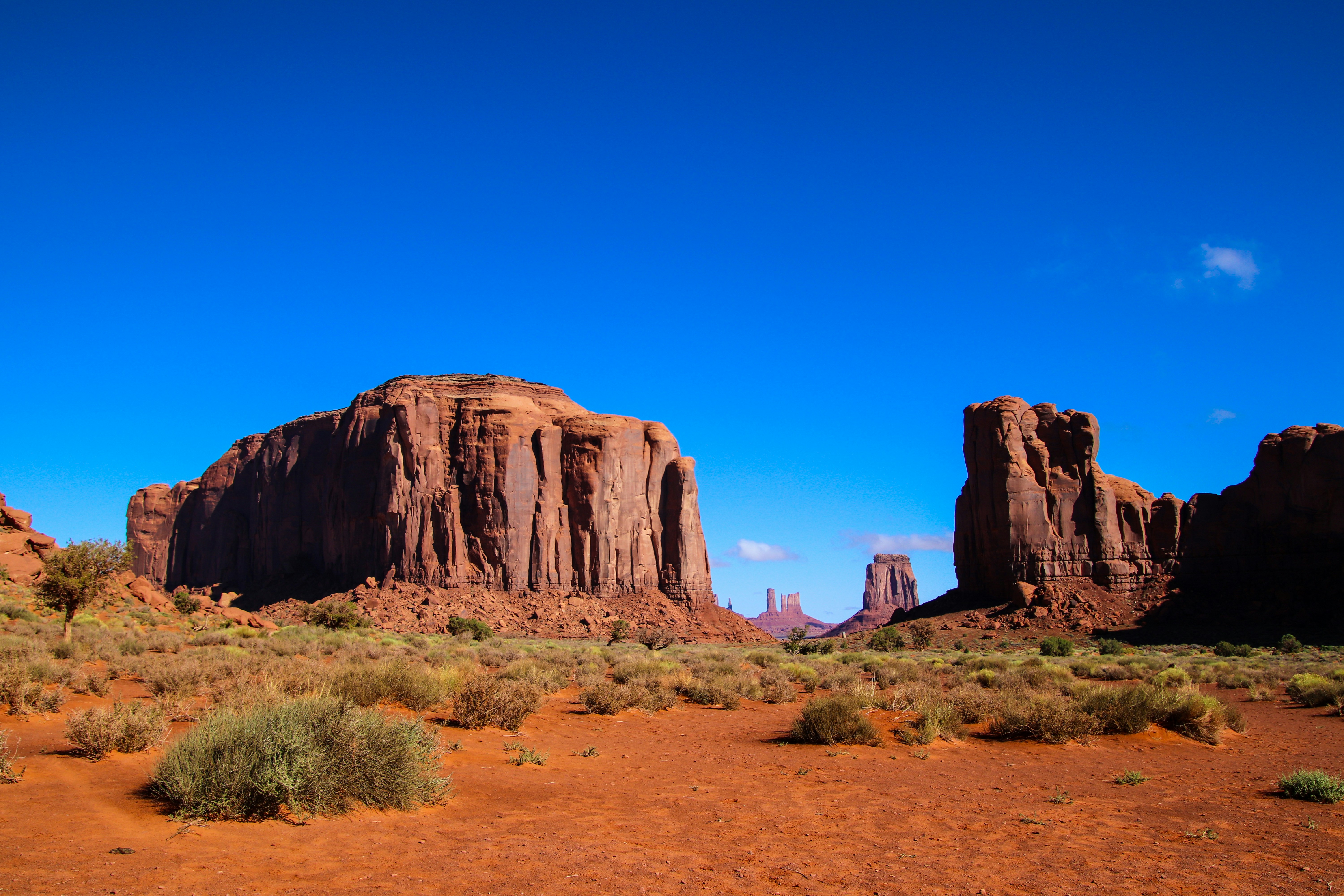 A desert scene with rocks and bushes in the foreground photo – Free ...