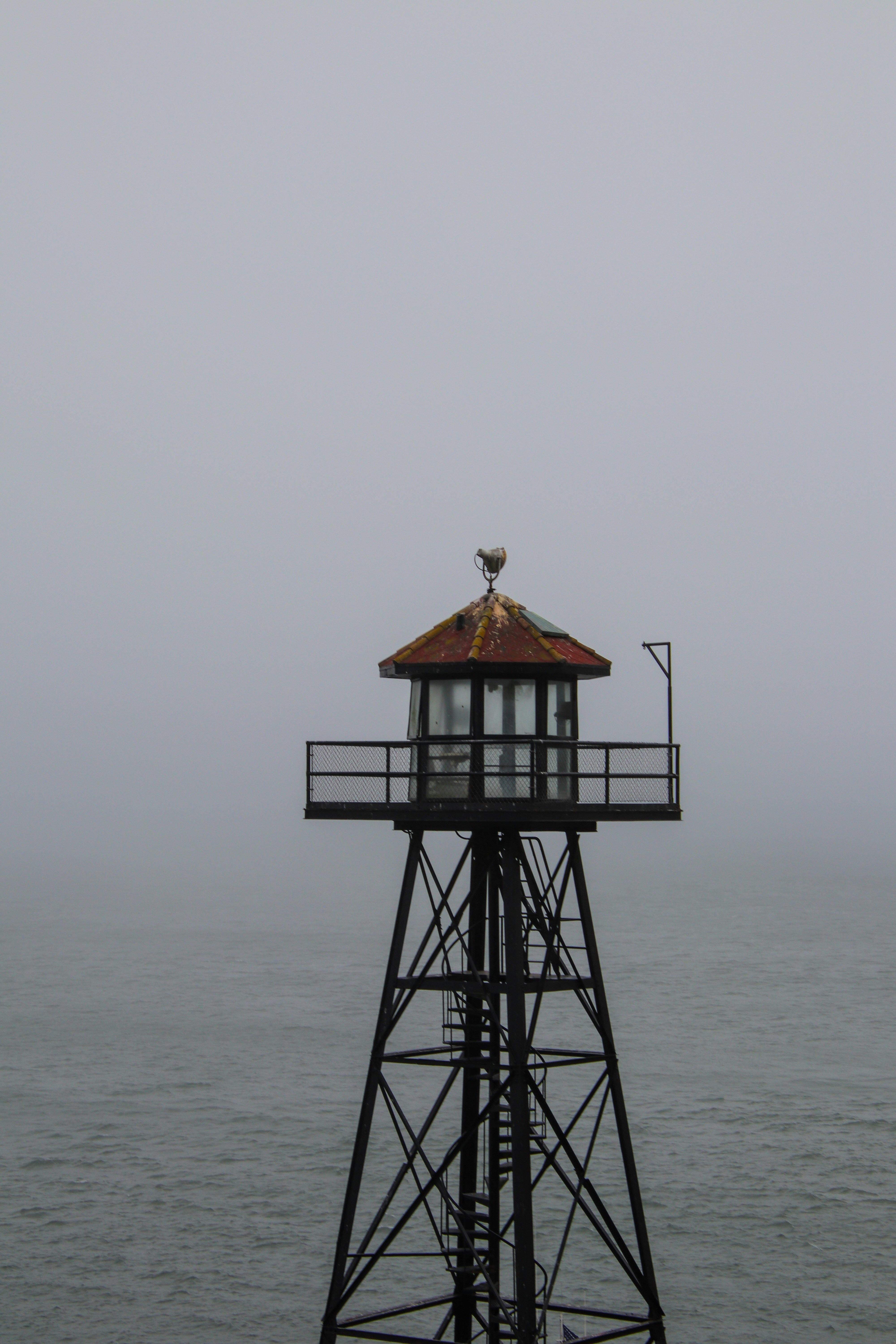 Beacon in the Mist: A Lattice Tower Over Quiet Seas