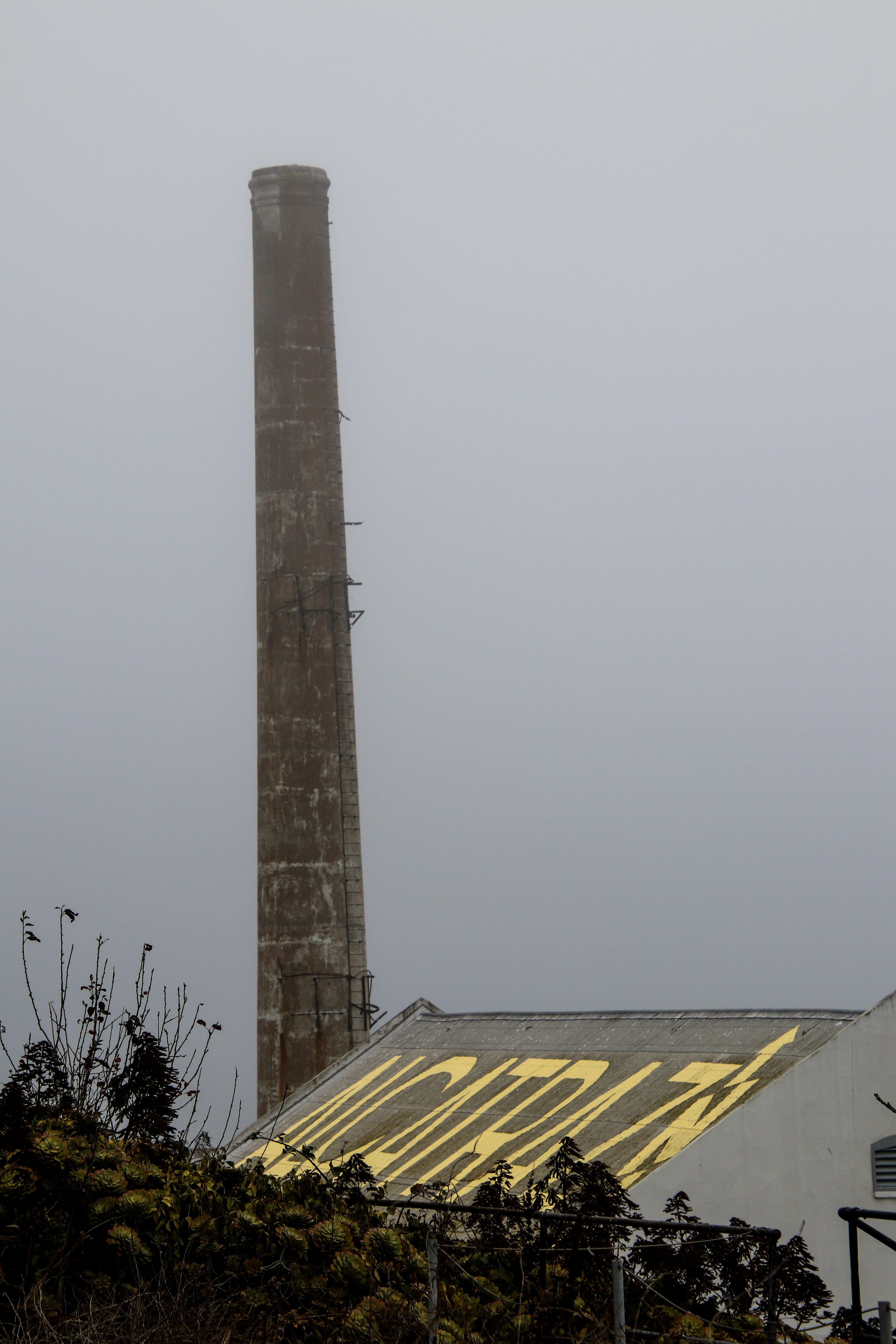 Fog-Soaked Chimney: A Silent Sentinel Over a Weathered Roof