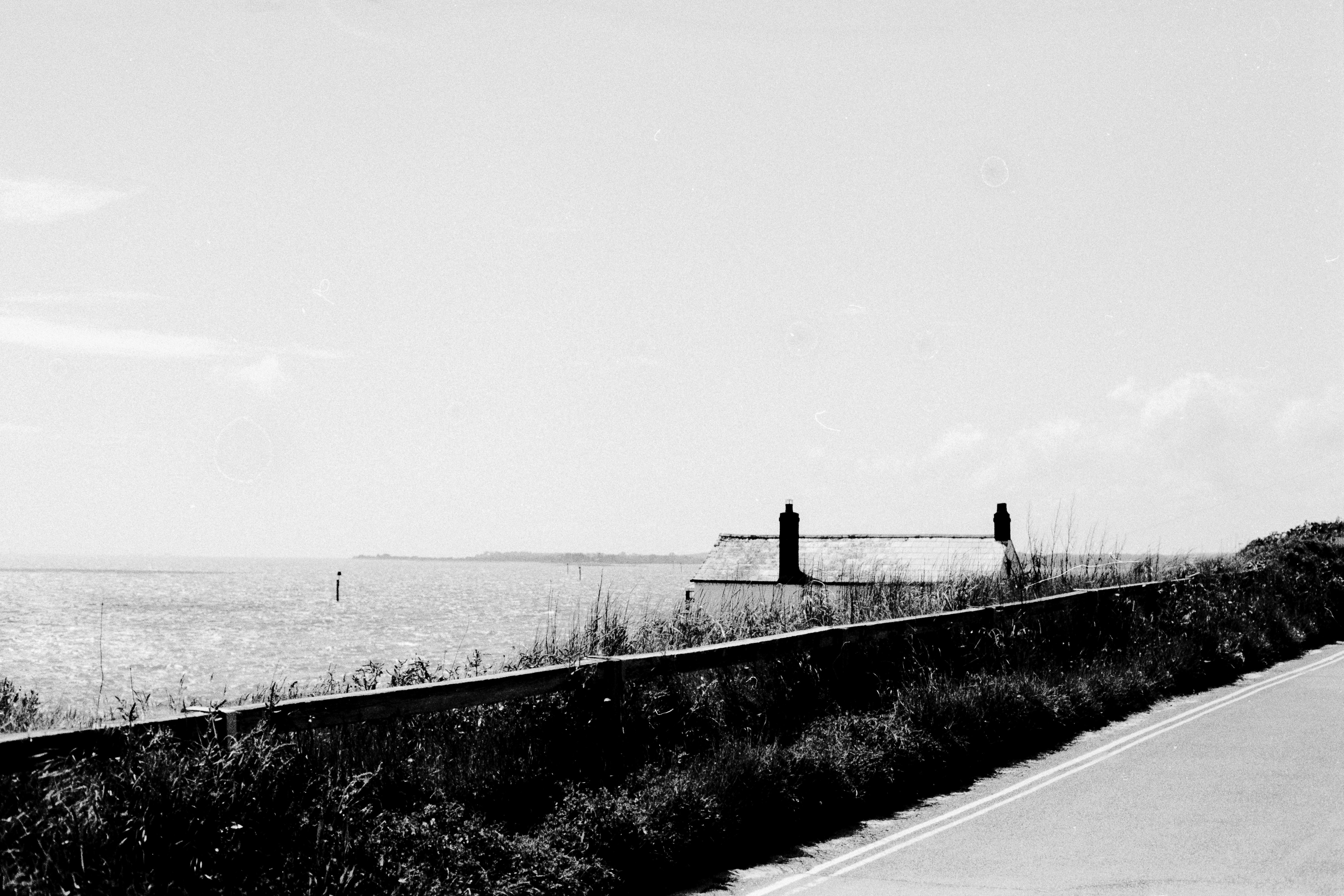 A black and white photo of a road near the ocean photo – Free Analog ...