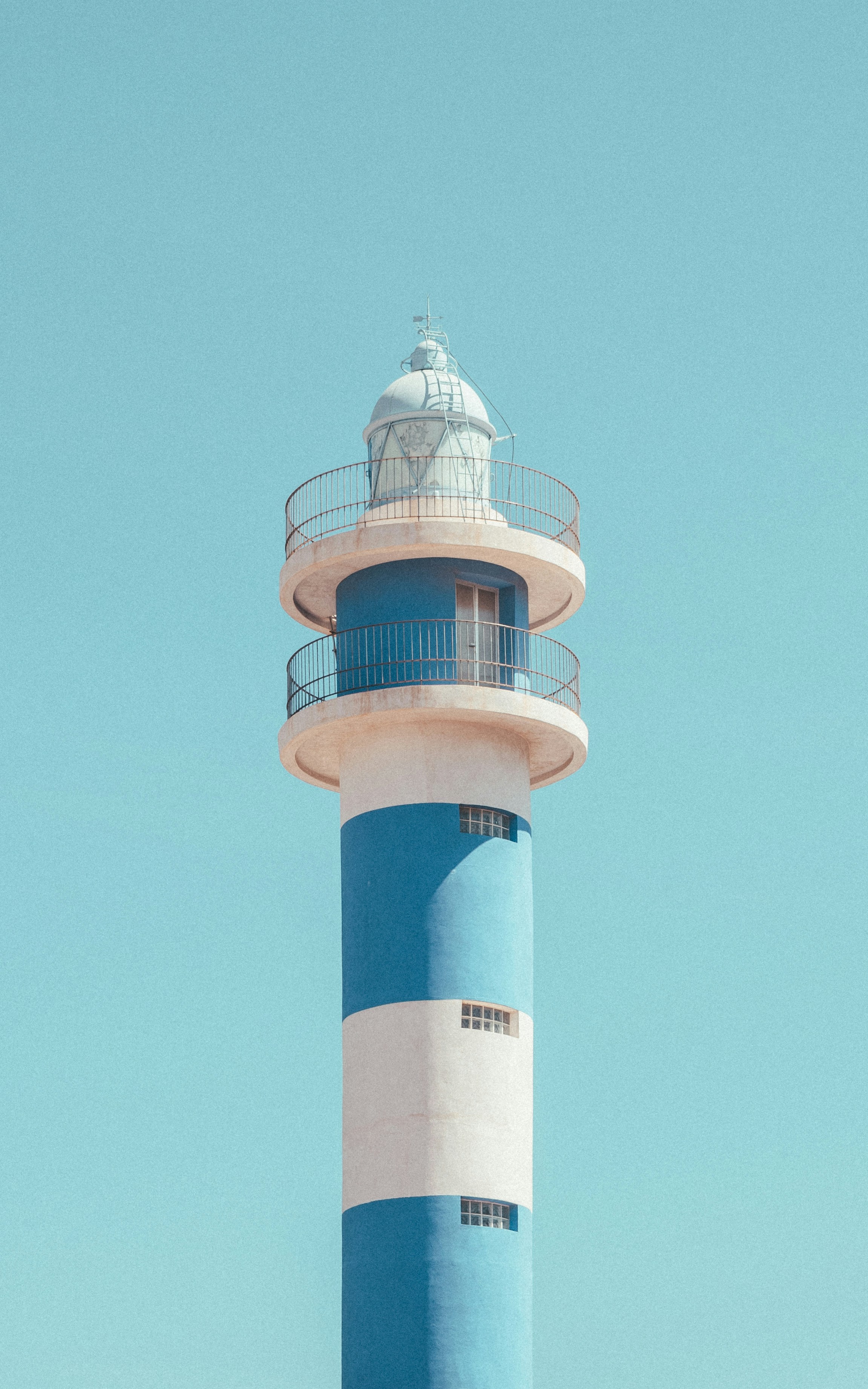 A blue and white lighthouse with a sky background photo – Free Beacon ...
