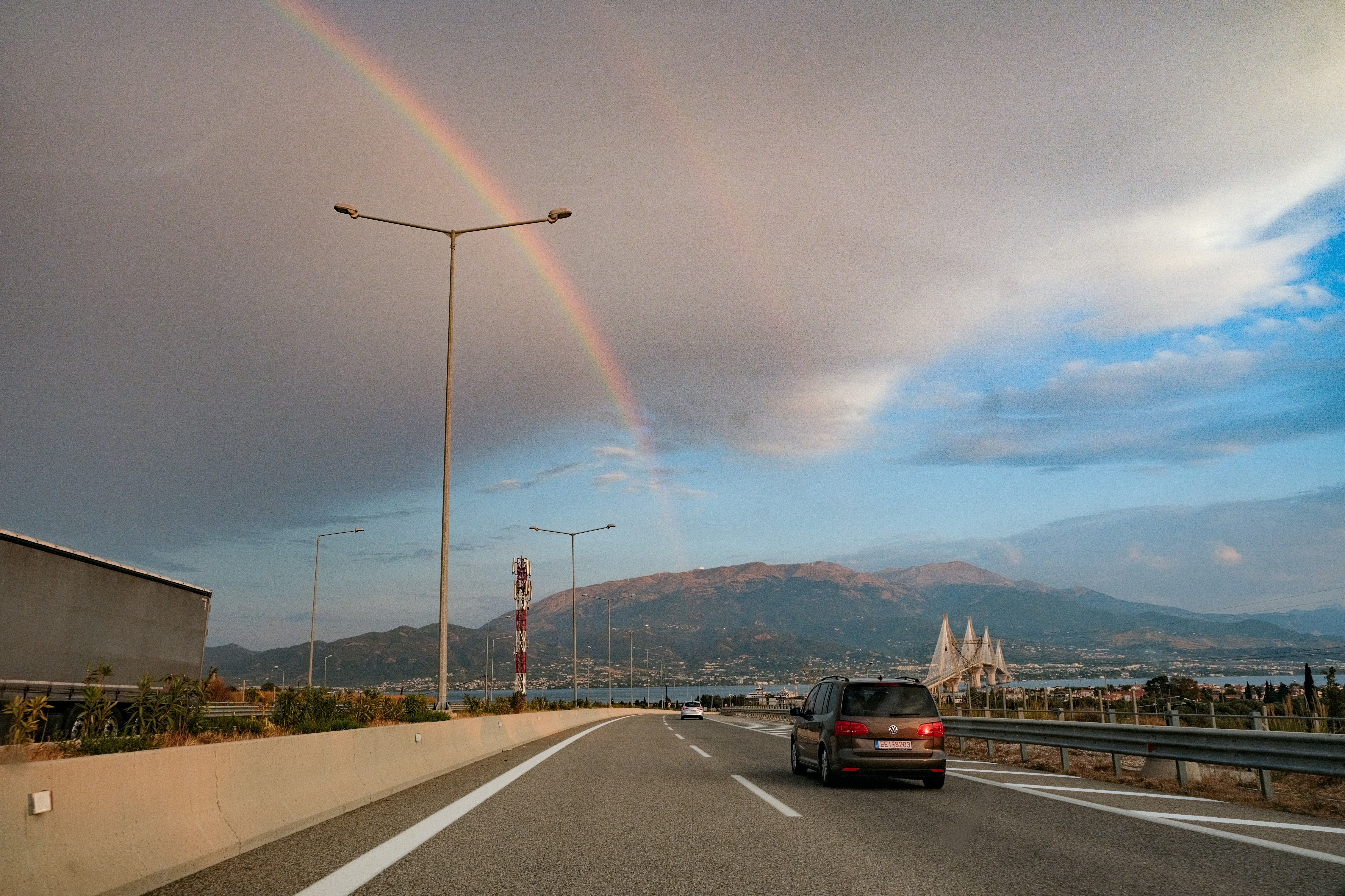 Double Rainbow Over the Open Highway with Mountain Backdrop