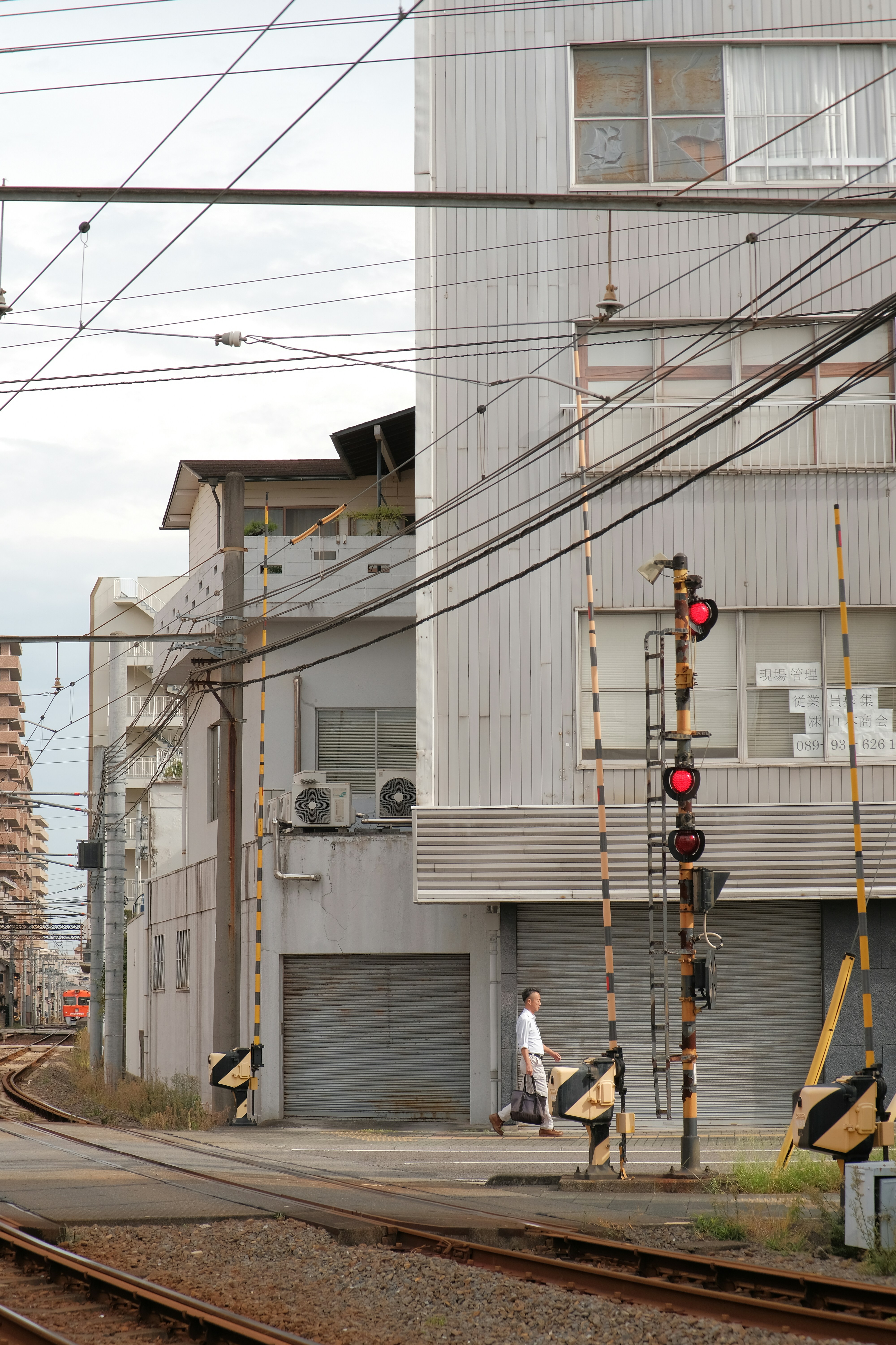 A train traveling down train tracks next to a tall building photo ...