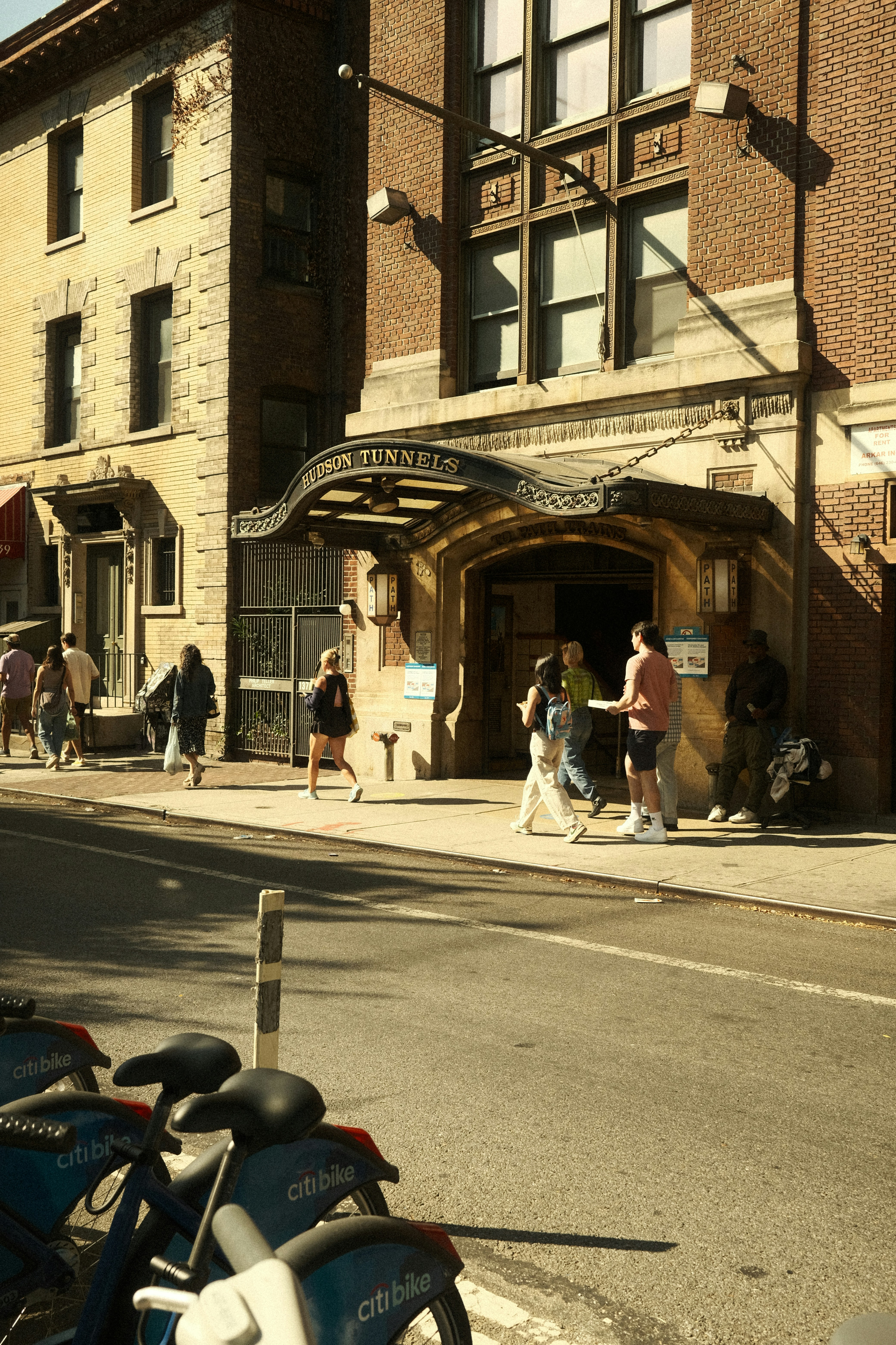 Sunlit Archway and City Walk: Pedestrians by the Hudson Tunnels