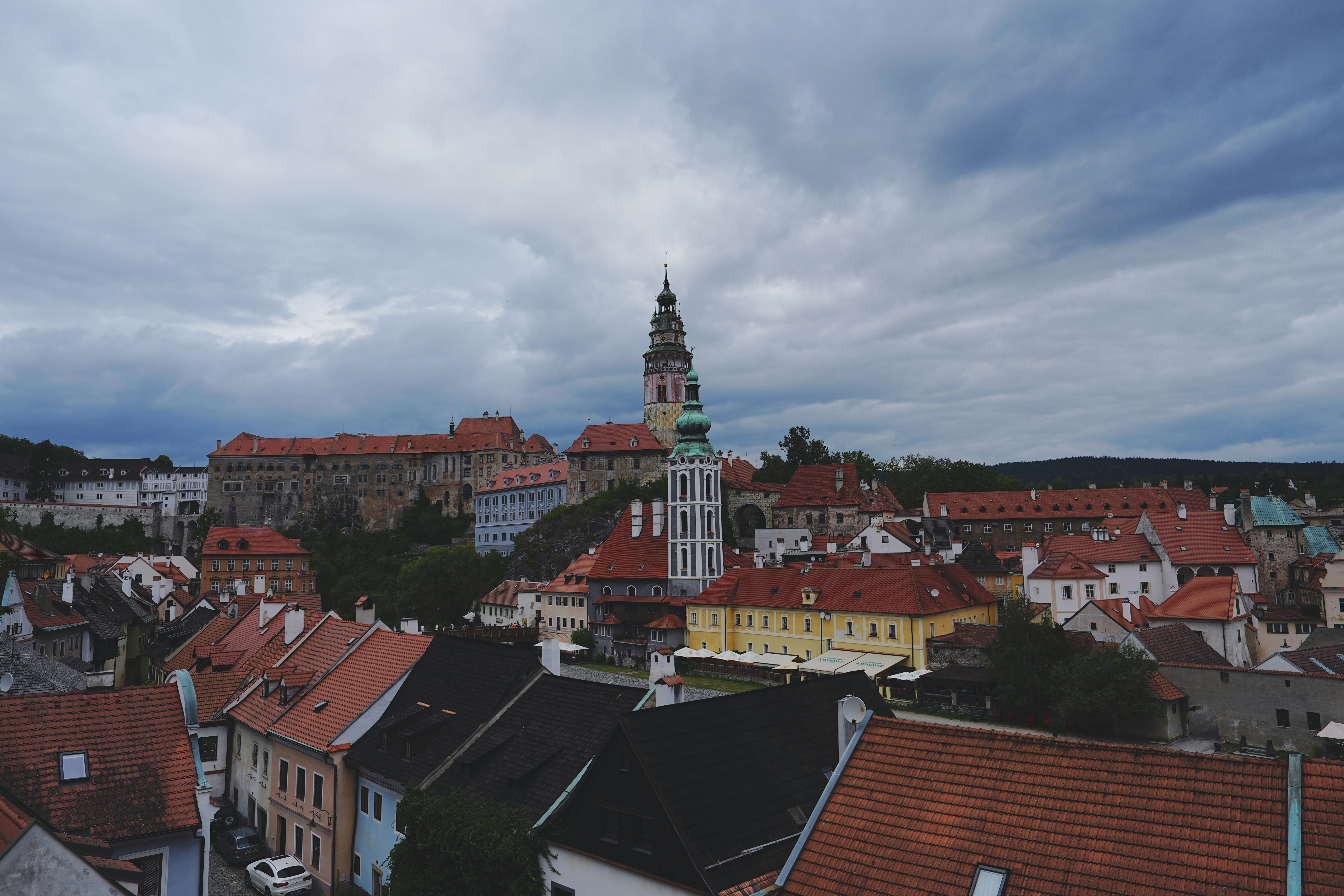 Historic buildings with vibrant rooftops nestled beneath a dramatic sky, showcasing the architectural beauty of a quaint town.