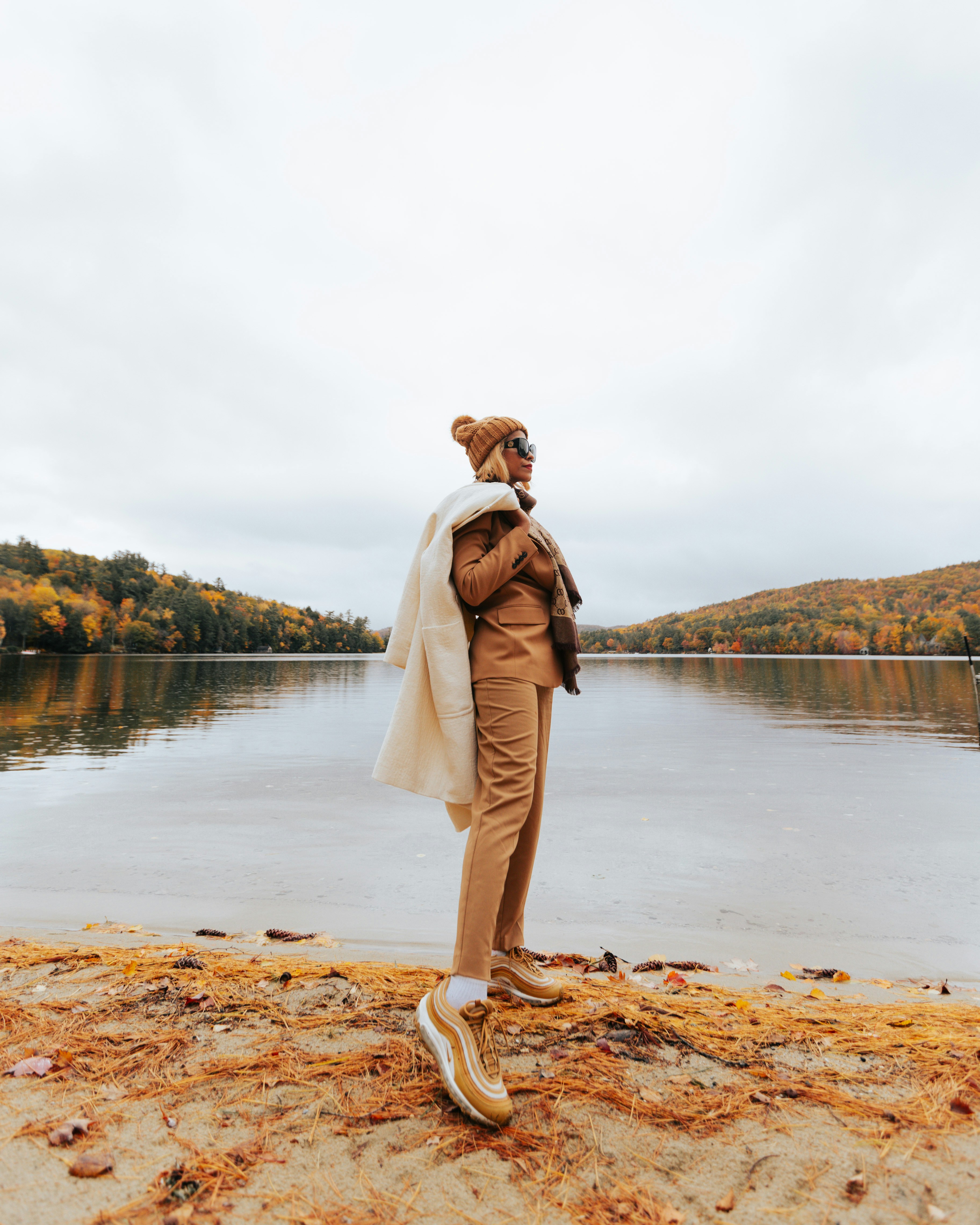 A woman standing on a beach next to a body of water