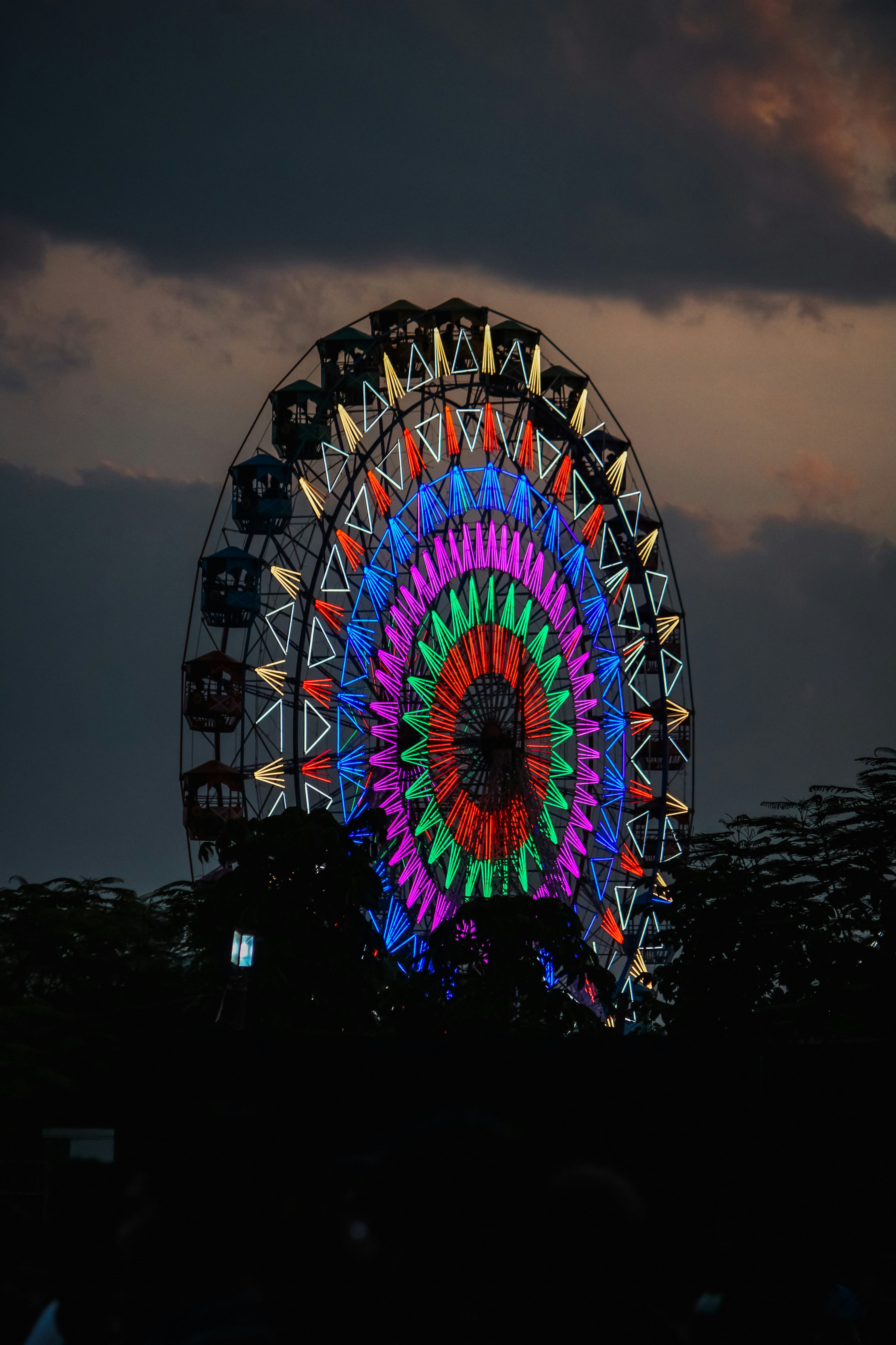 Neon Ring at Night: A Rainbow-Lit Ferris Wheel