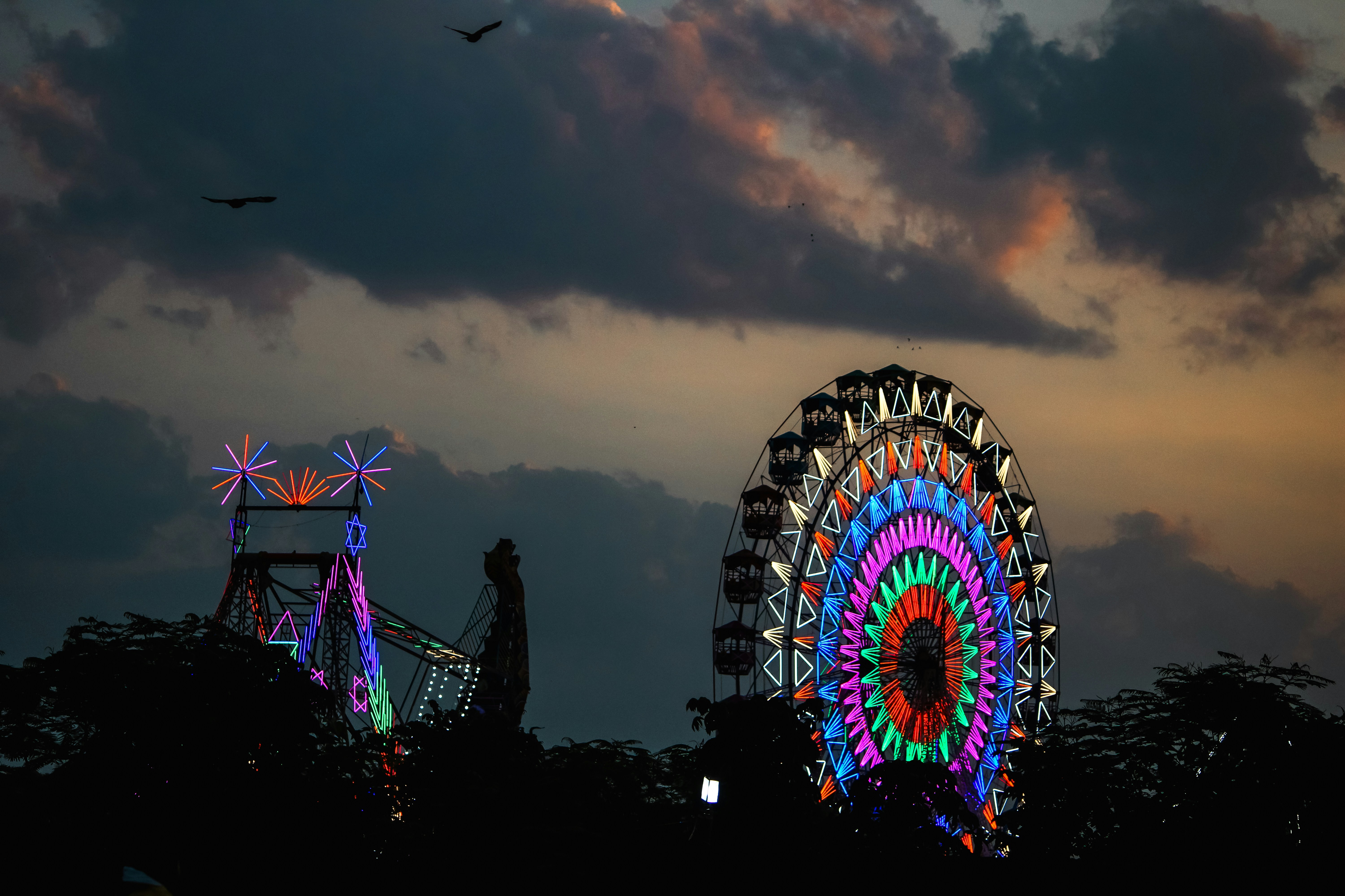 Twilight Neon Wheels: Carnival Lights Turning the Dusk
